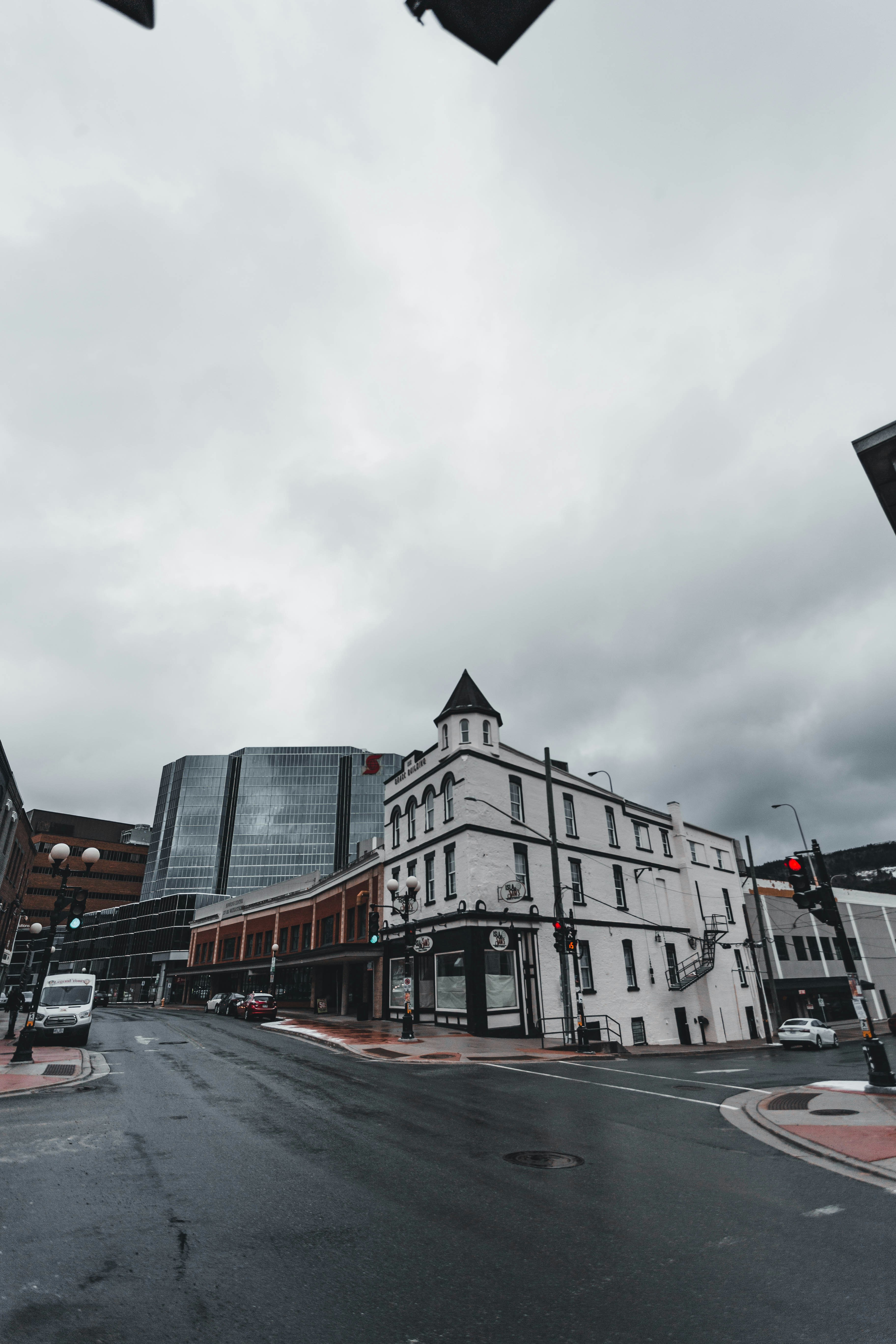 City street corner with historic and modern buildings under a cloudy sky.