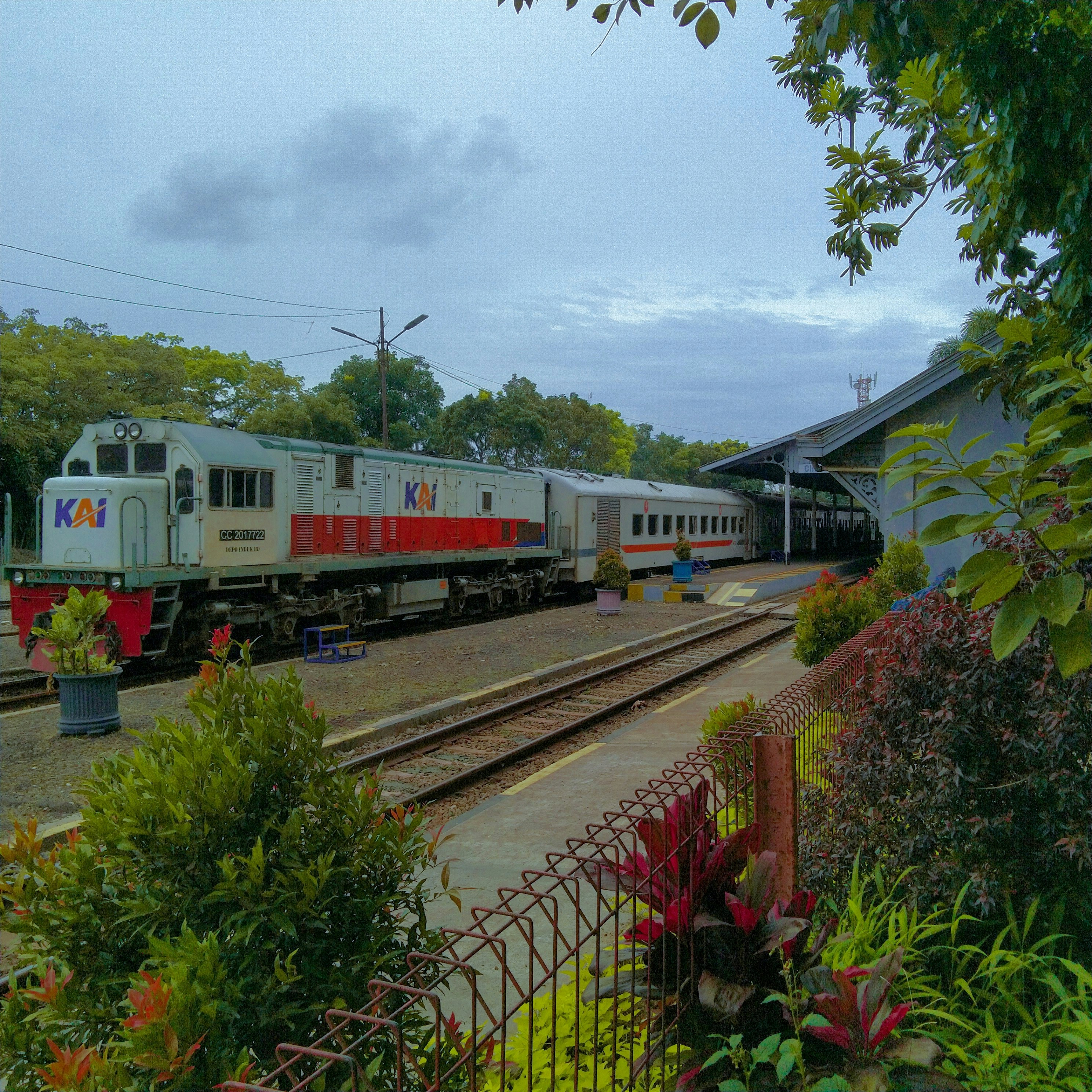 A train on a train track next to a building photo – Free Transportation ...