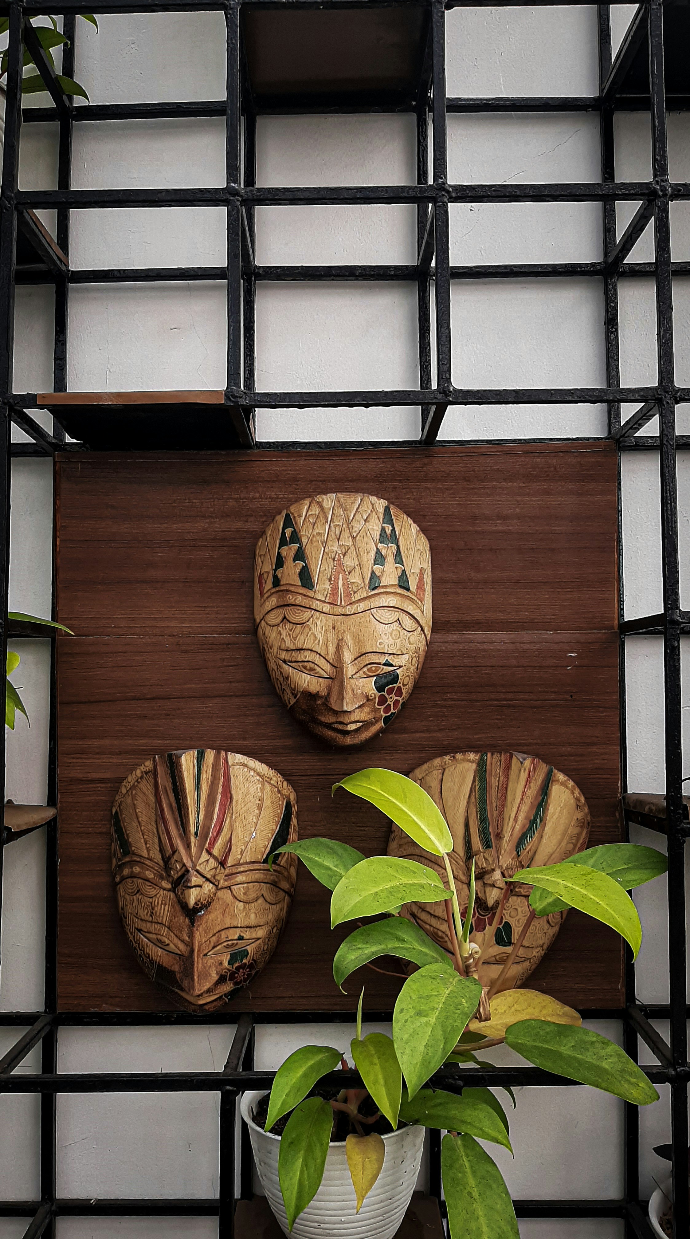 Wooden Masks in a Grid: A Quiet Portrait of Texture and Line