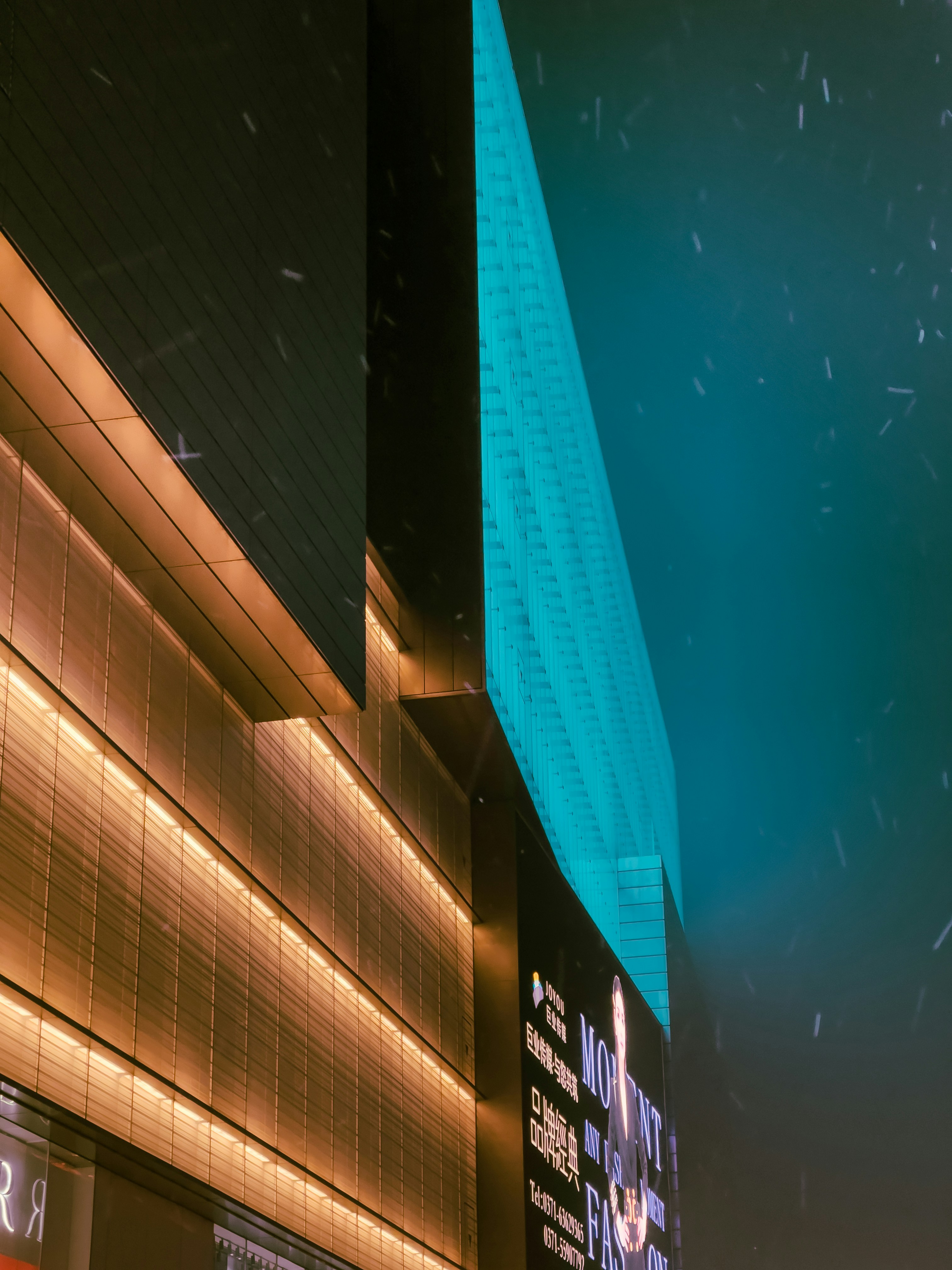 Neon Blue Spire Rising Over a Warm-Glowed Facade