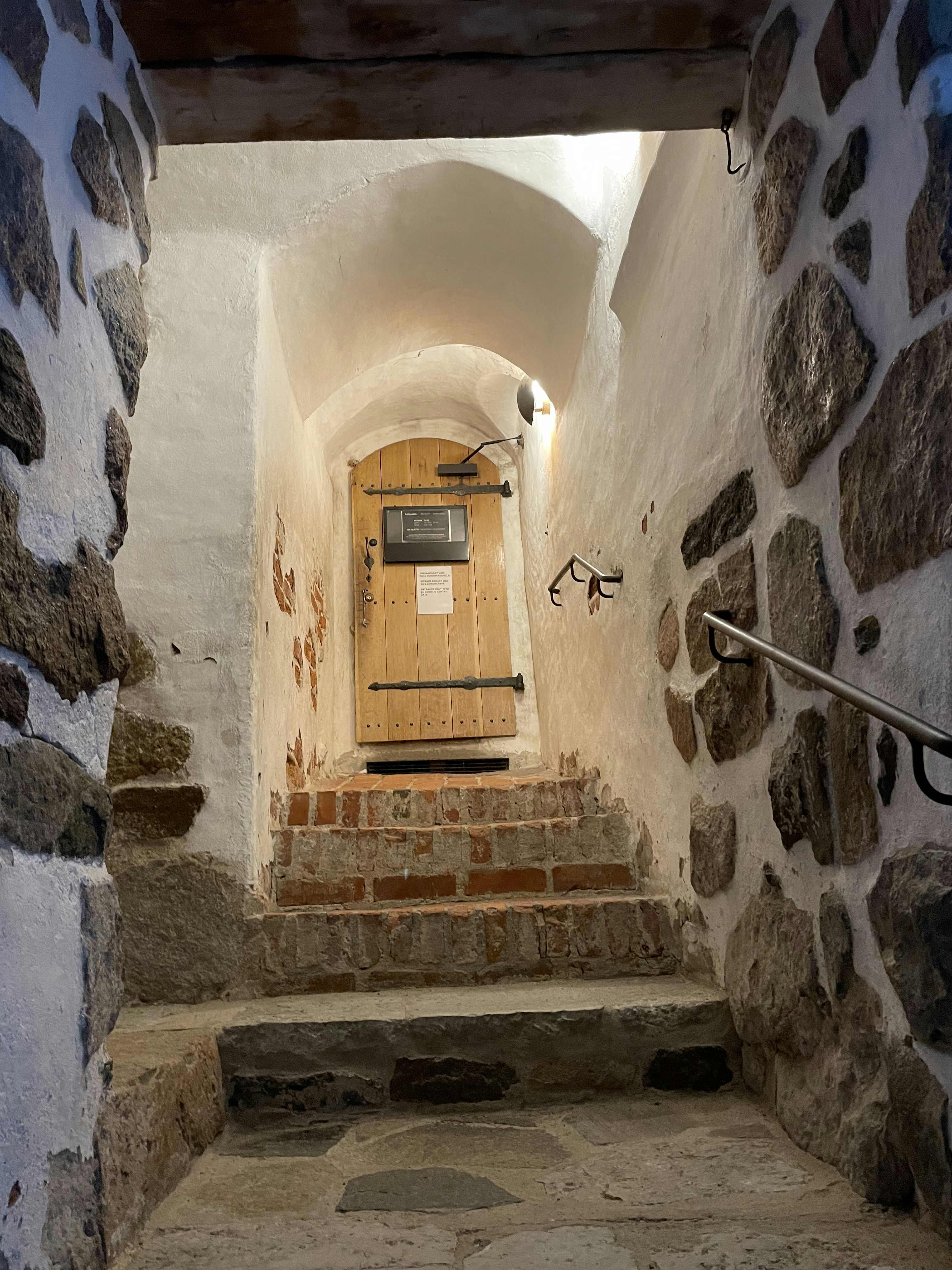 Lantern-Lit Ascent: A Stone Staircase Framing a Wooden Door