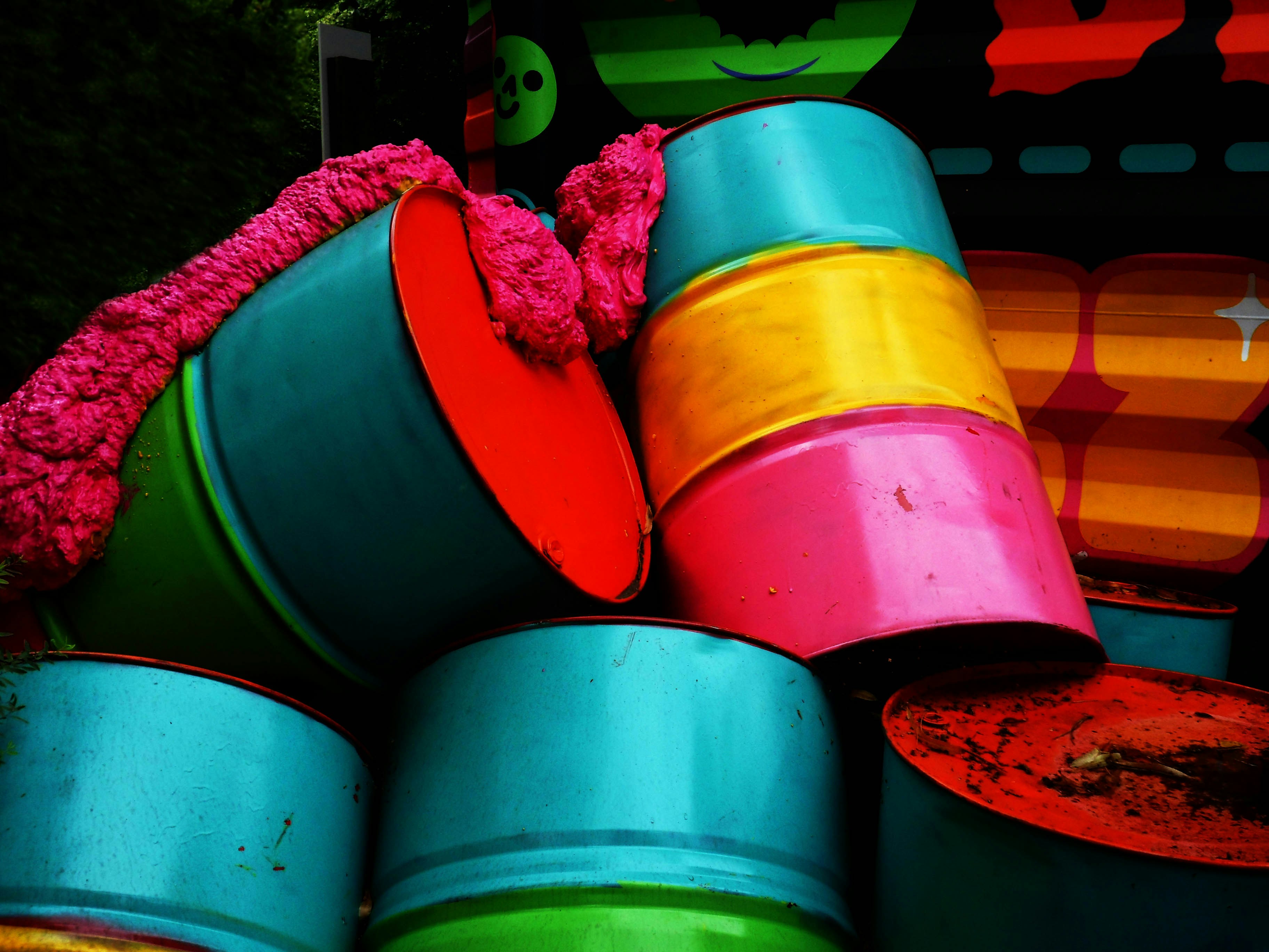 A dynamic arrangement of brightly colored barrels, featuring vivid pink, orange, and teal hues, creating a playful visual impact.