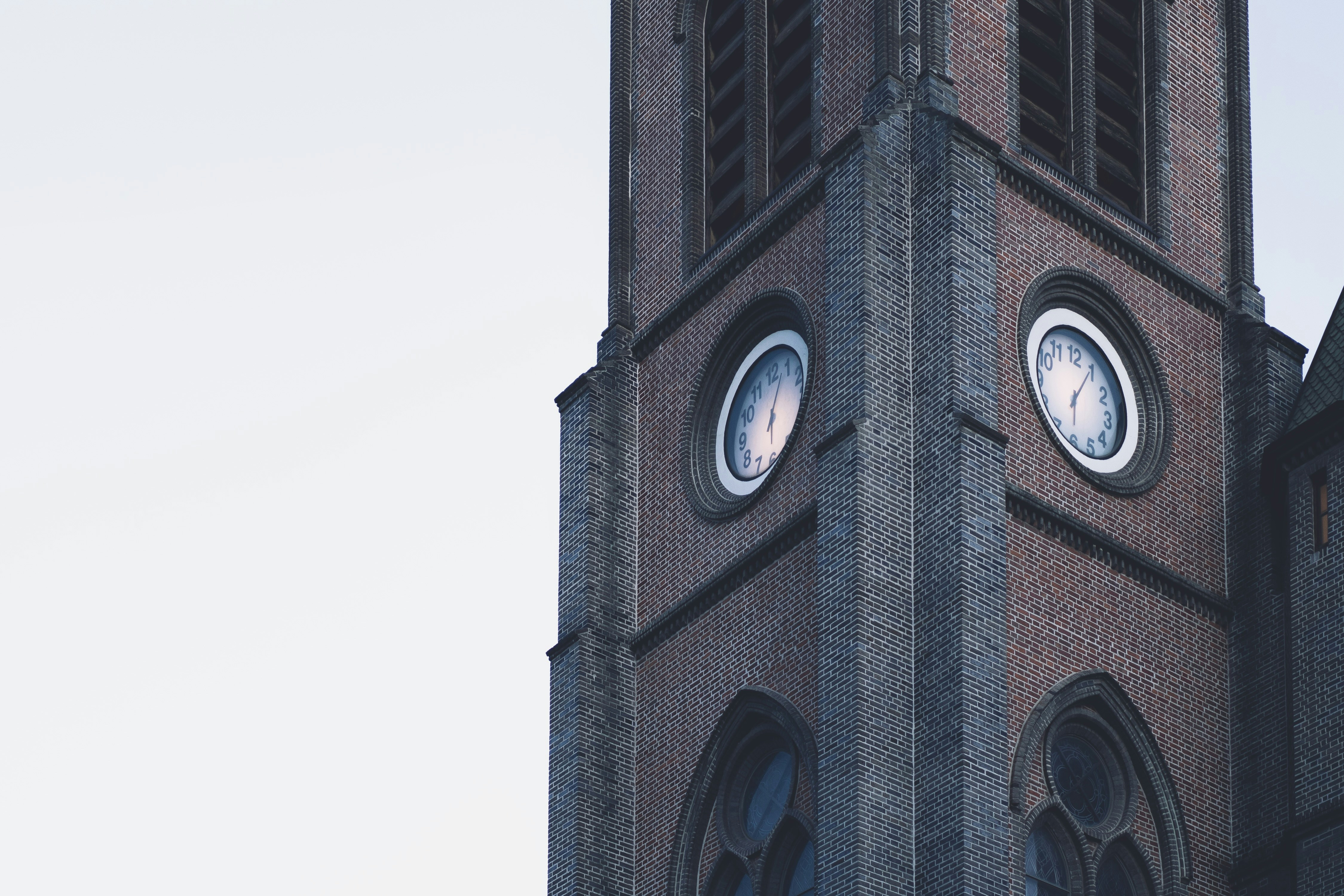 Close-up view of a historic clock tower showcasing intricate brickwork and classic clock faces.