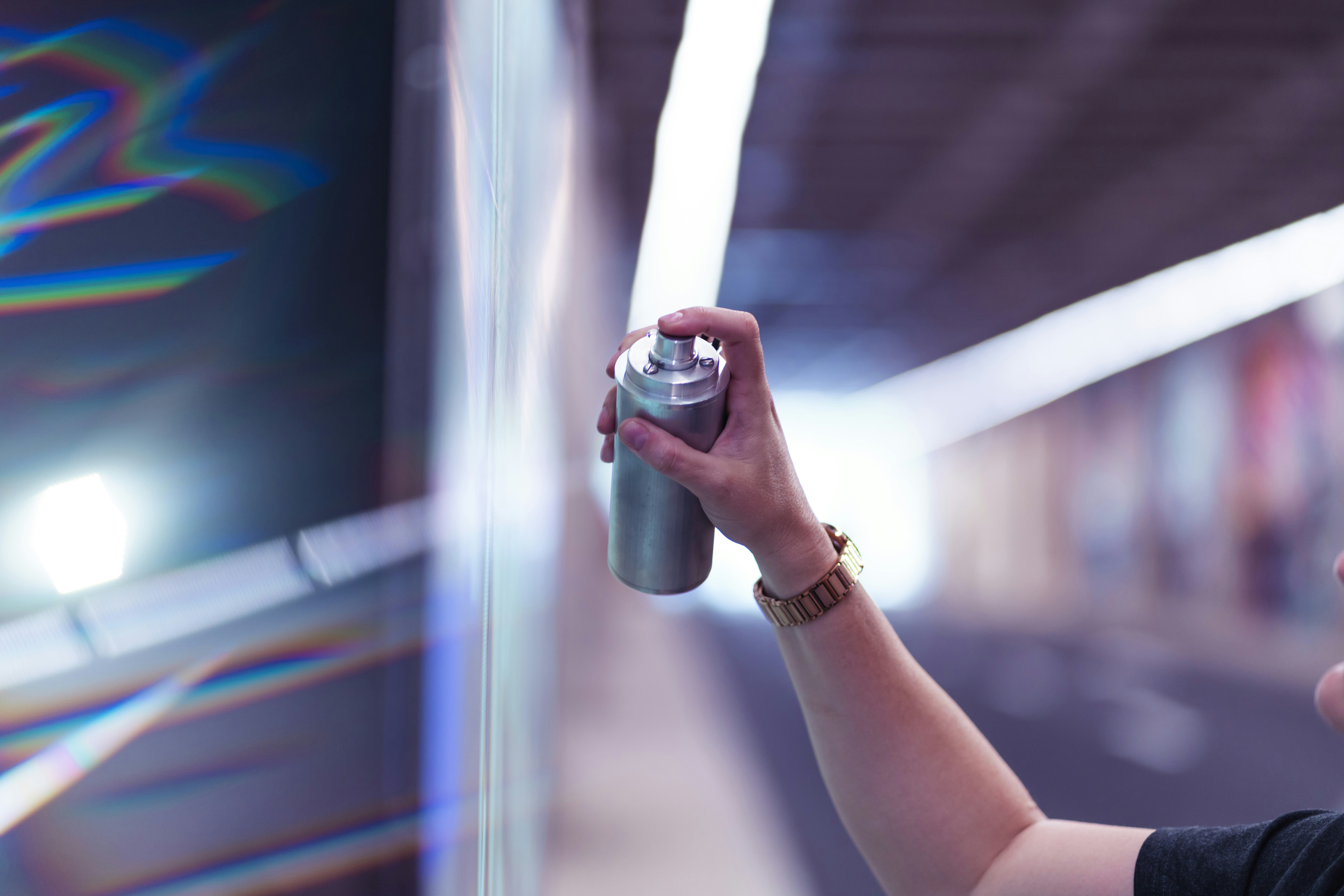 A woman spray painting a wall with a spray can photo – Free Usa Image ...