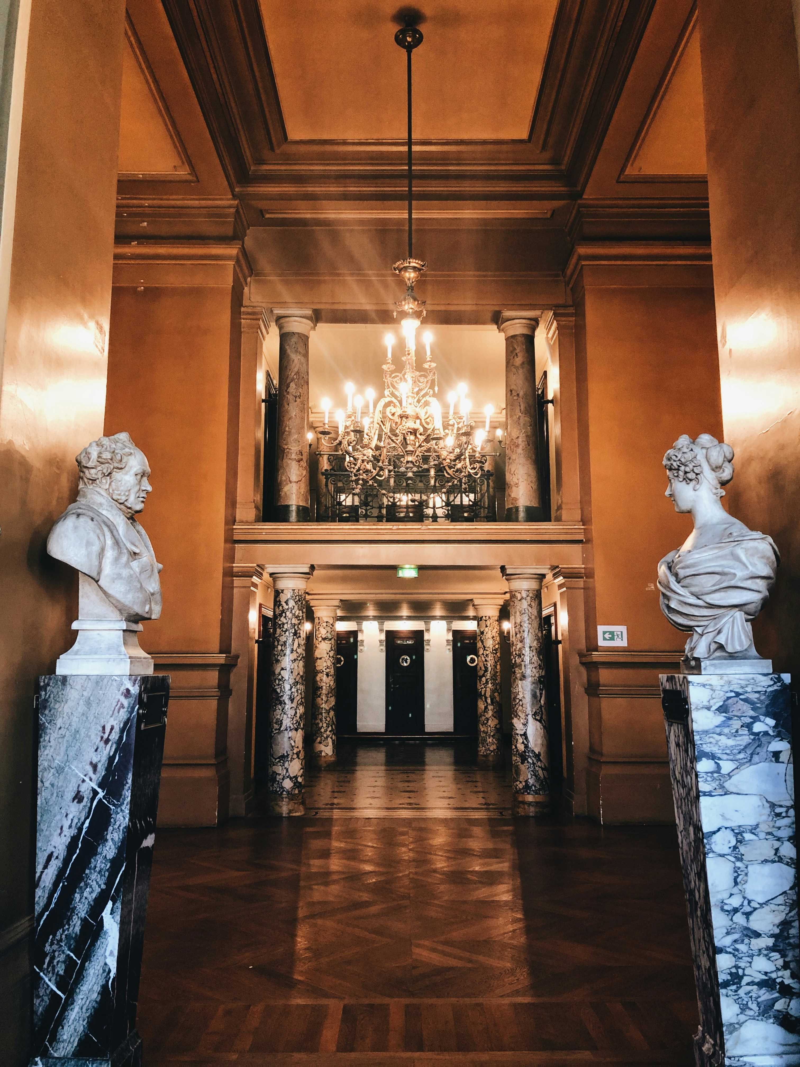 A large hall with a chandelier and marble busturines photo – Free Paris ...