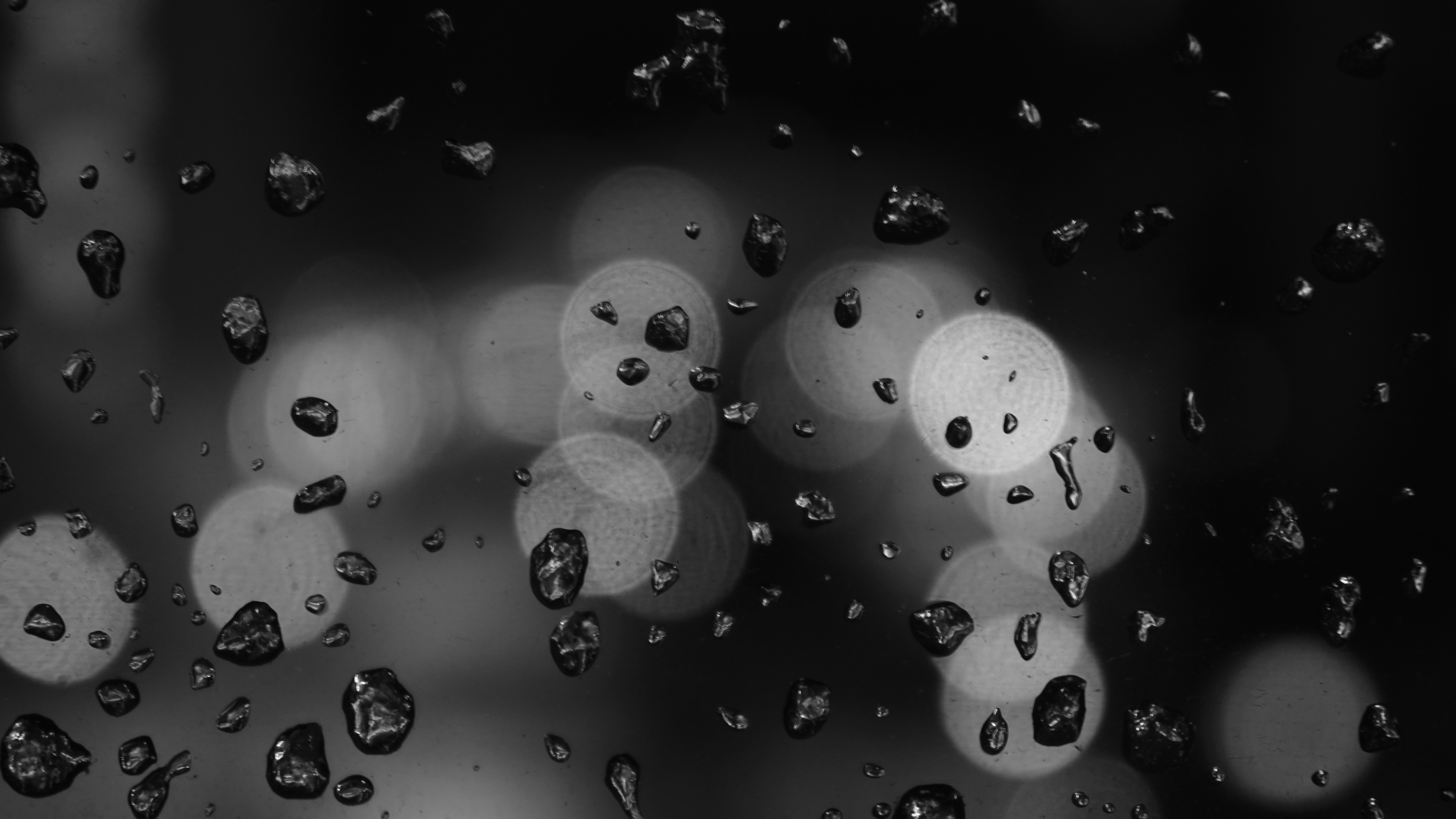 Monochrome Rain Mosaic: Droplets on a Glass Window with City Bokeh