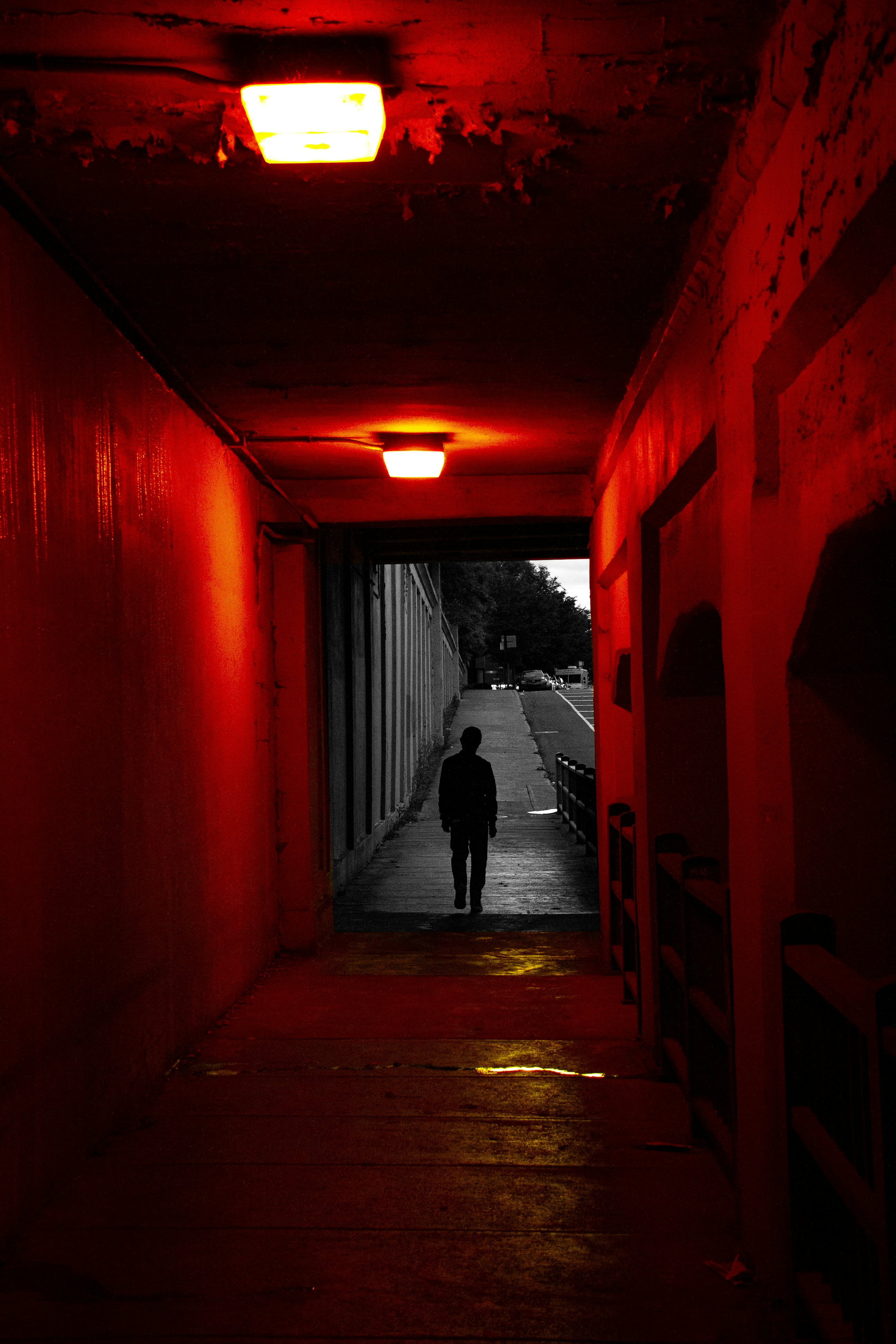 A person walking down a dark hallway with red lights photo – Free ...