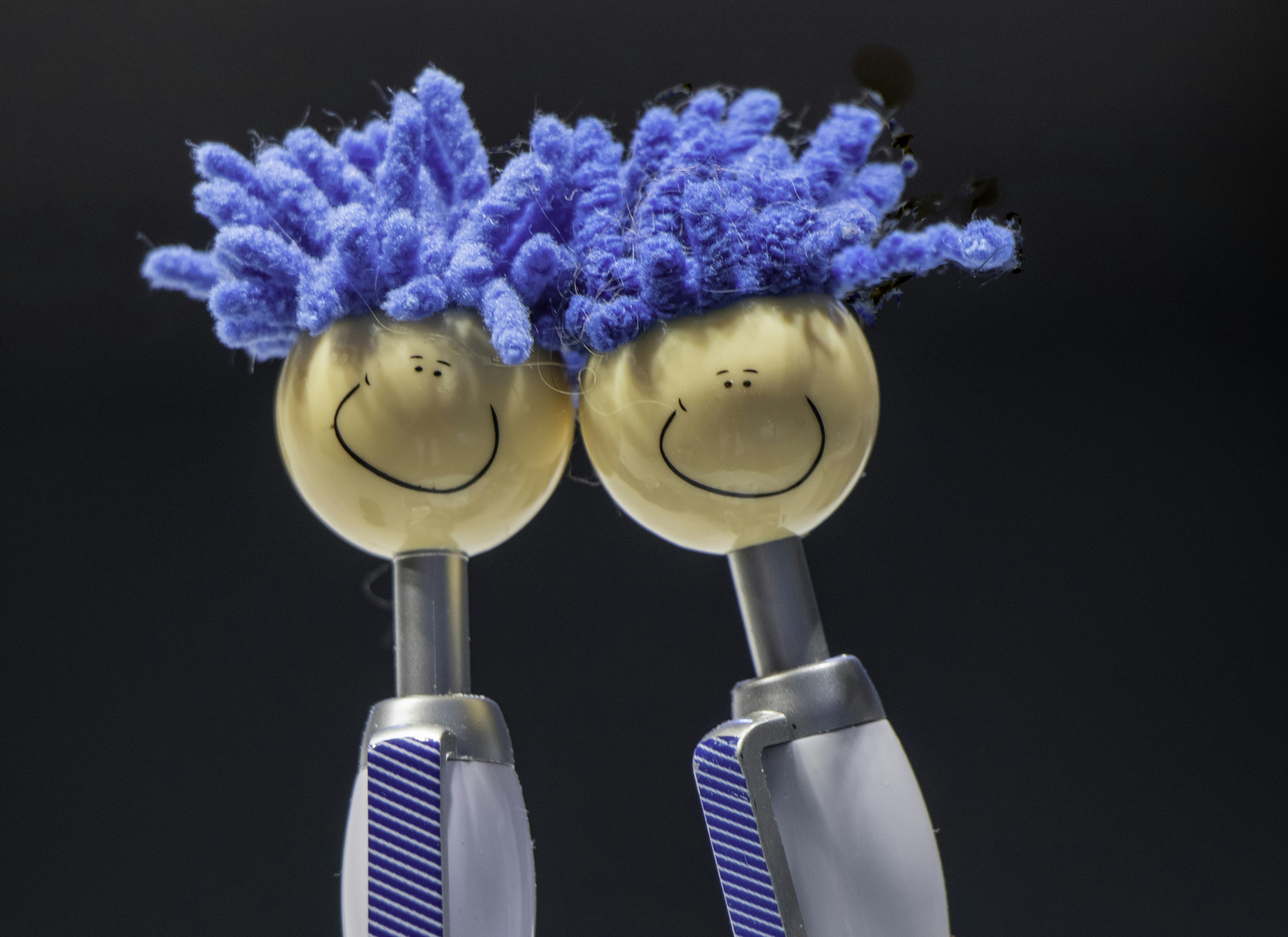 A couple of toothbrushes with blue hair on top of them photo – Free ...