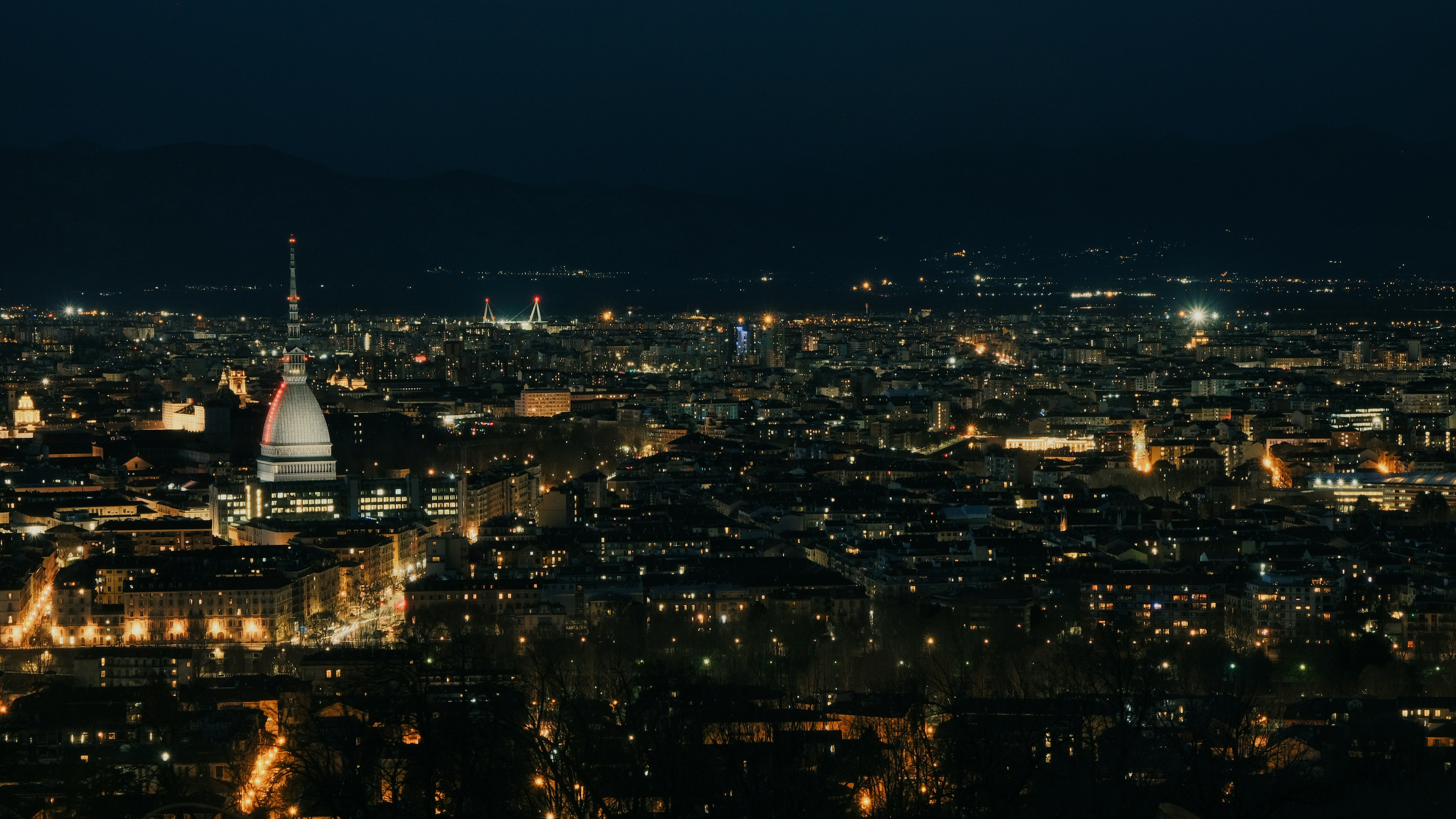 Una vista de una ciudad por la noche desde la cima de una colina foto ...