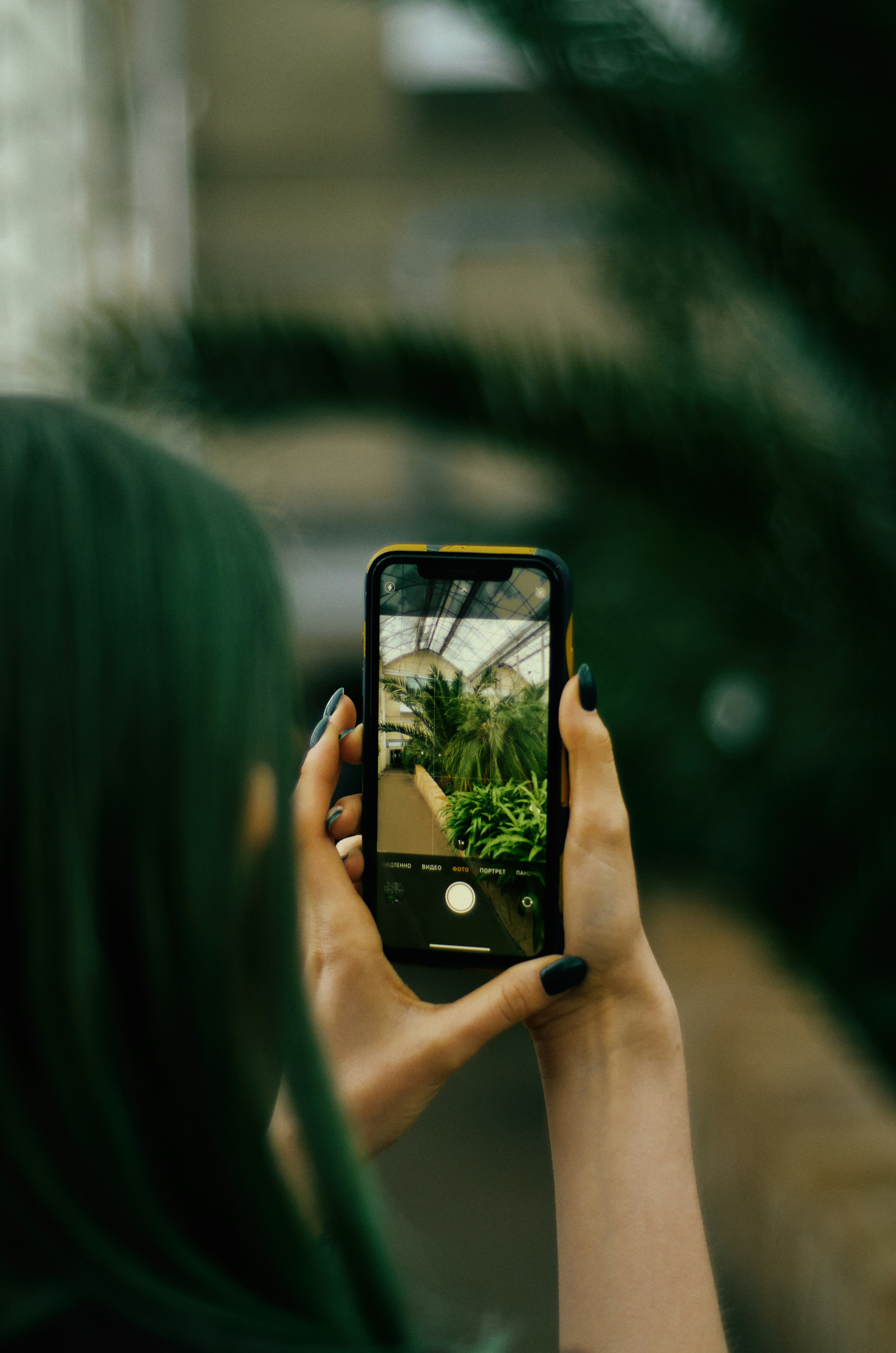 A hand holding a cellphone in front of a mirror posing for the camera ...