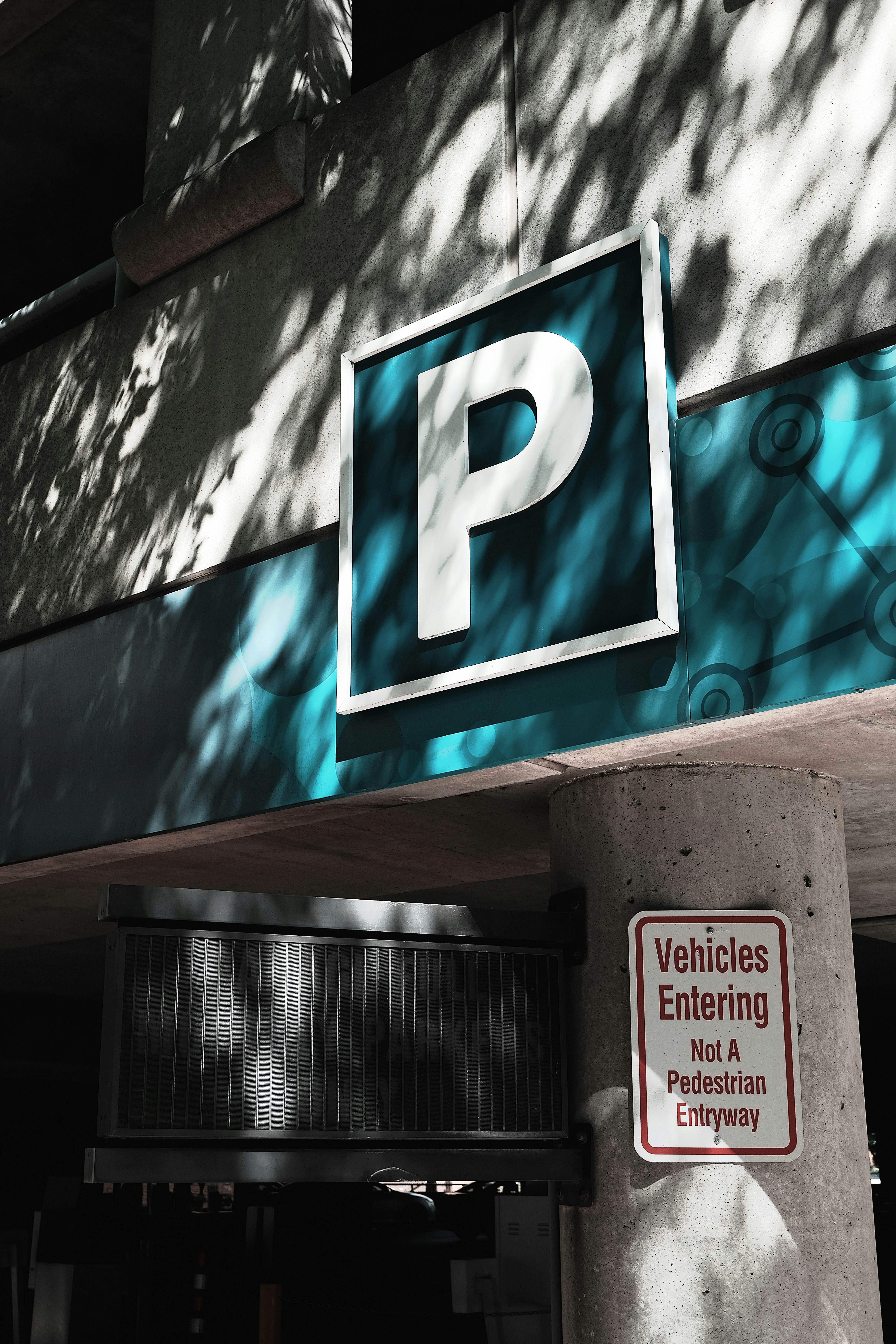 Shade and Signage: Parking Entrance Under Dappled Light