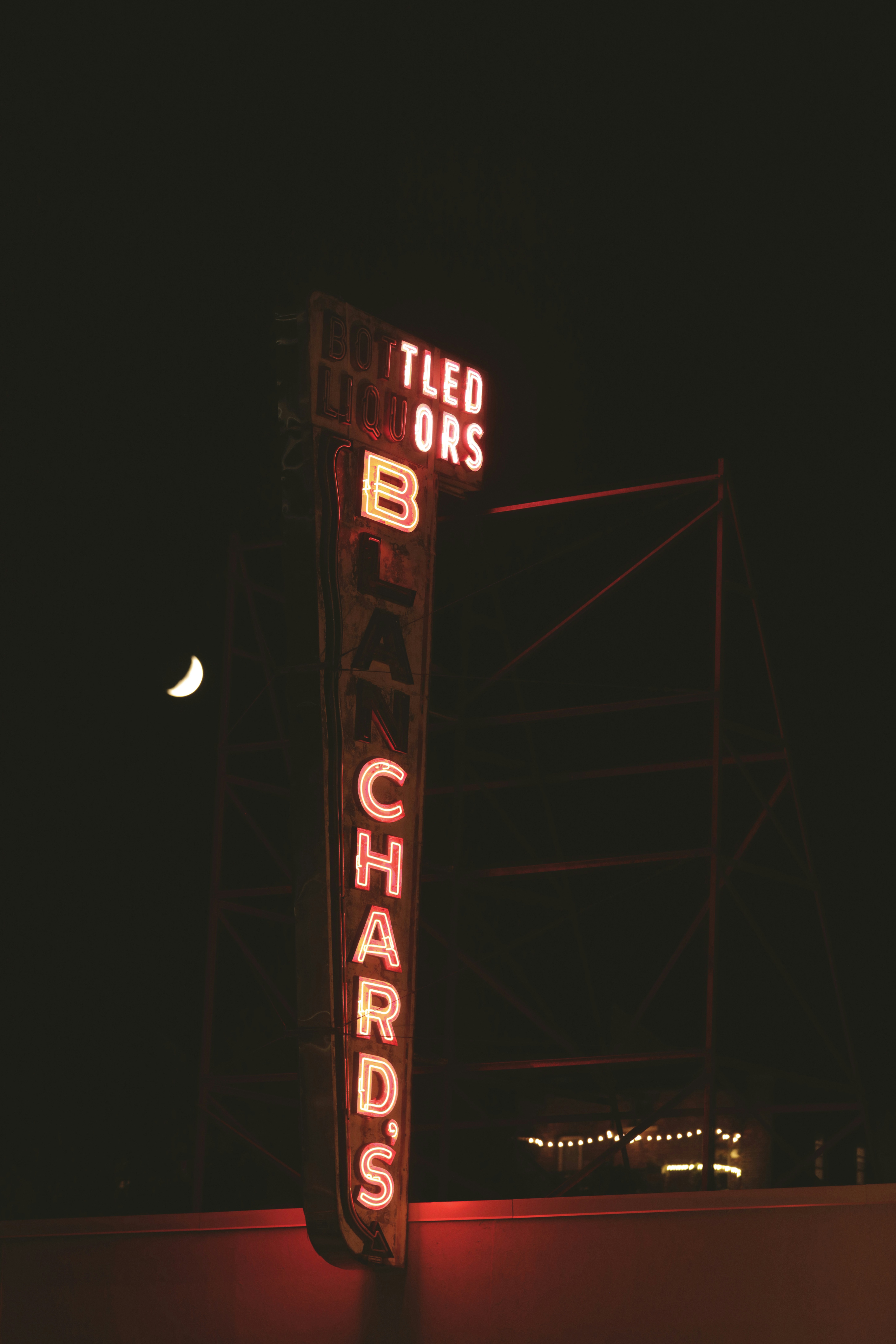 Crimson Neon at Blanchard's: Moonlit Sign Amid Steel