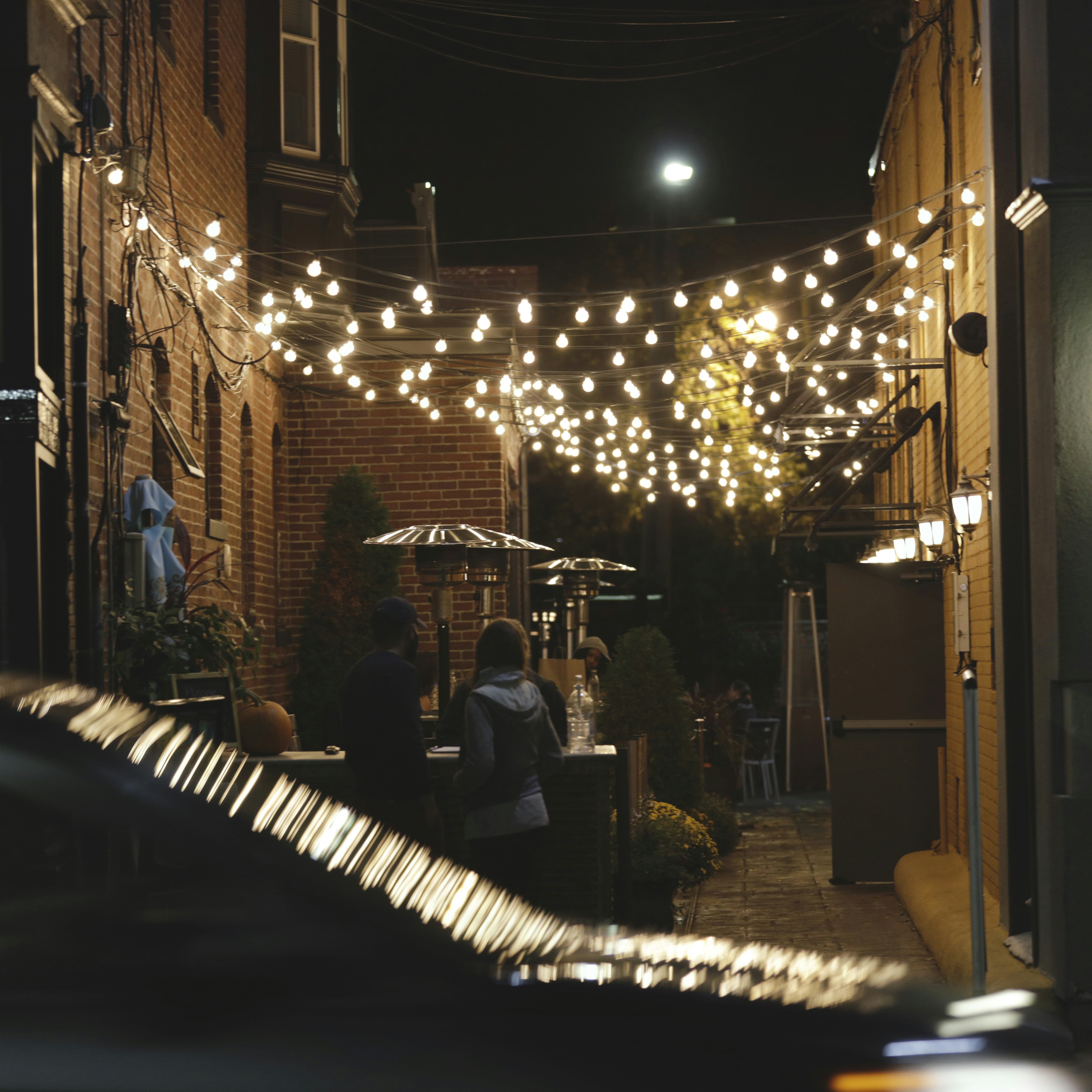 String Lights Over a Narrow Alley Café