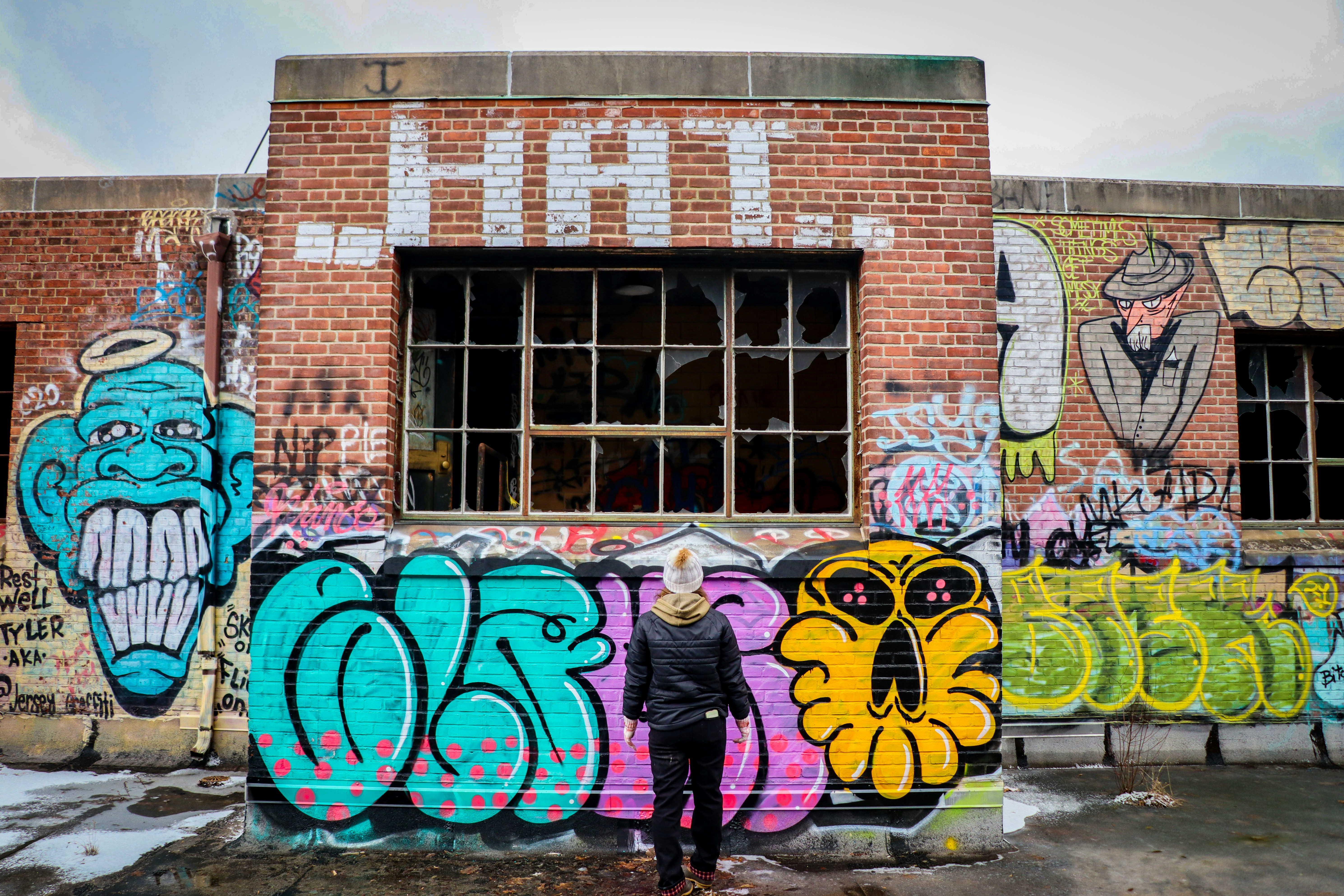 Solitary Figure Framed by a Graffiti-Wrapped Warehouse
