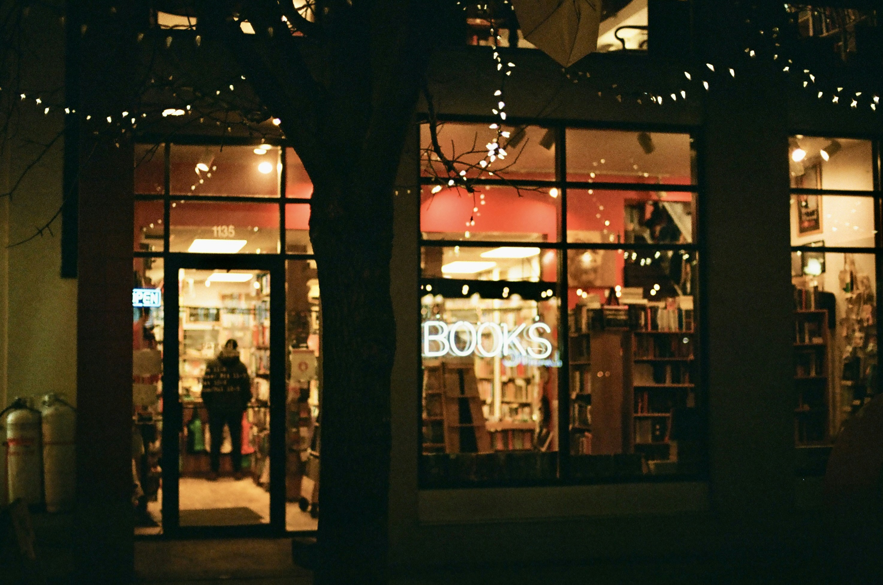 Une devanture de magasin la nuit avec un arbre devant photo – Photo ...