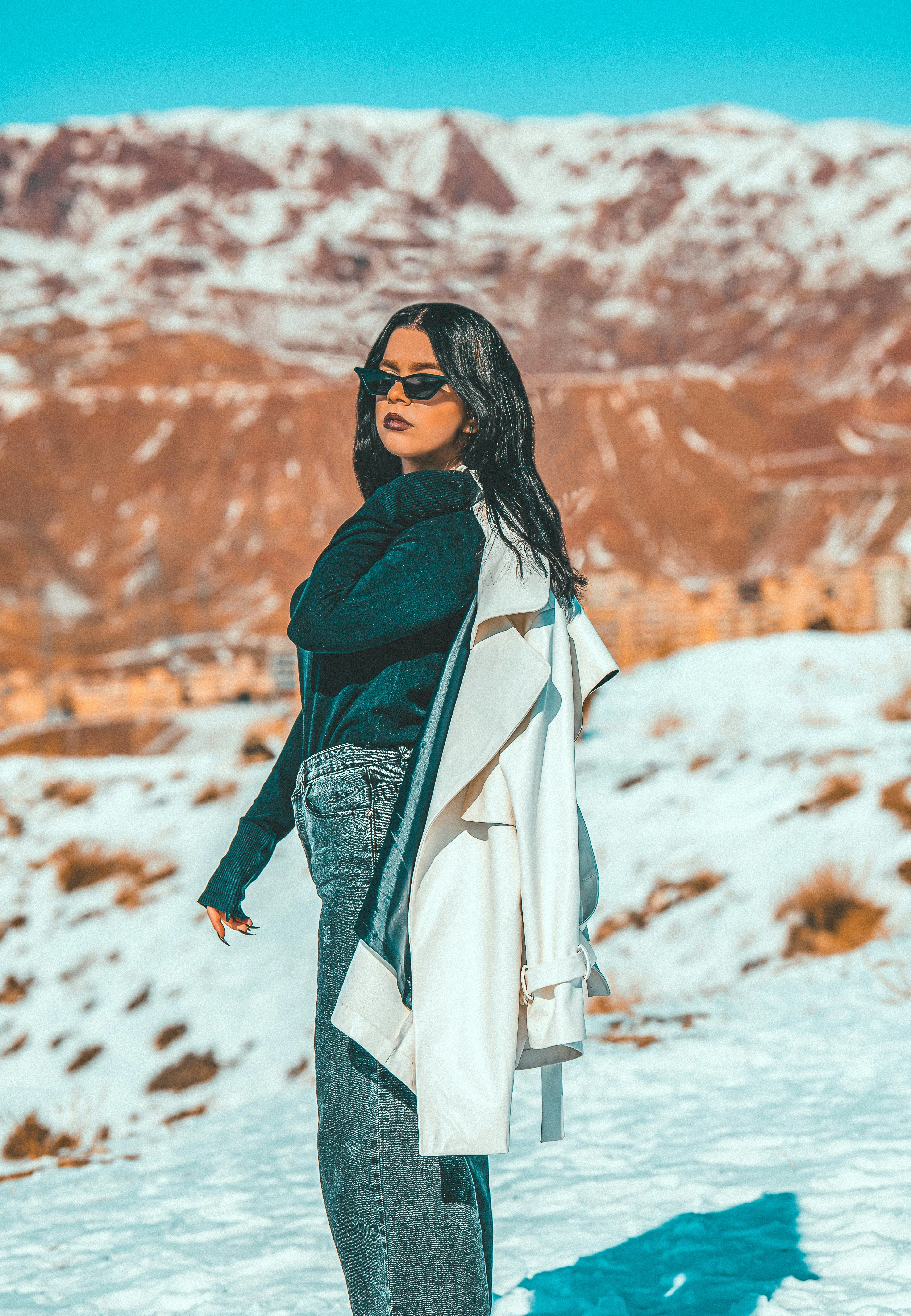 Foto zum Thema Eine Frau, die mit einem Schal im Schnee steht ...