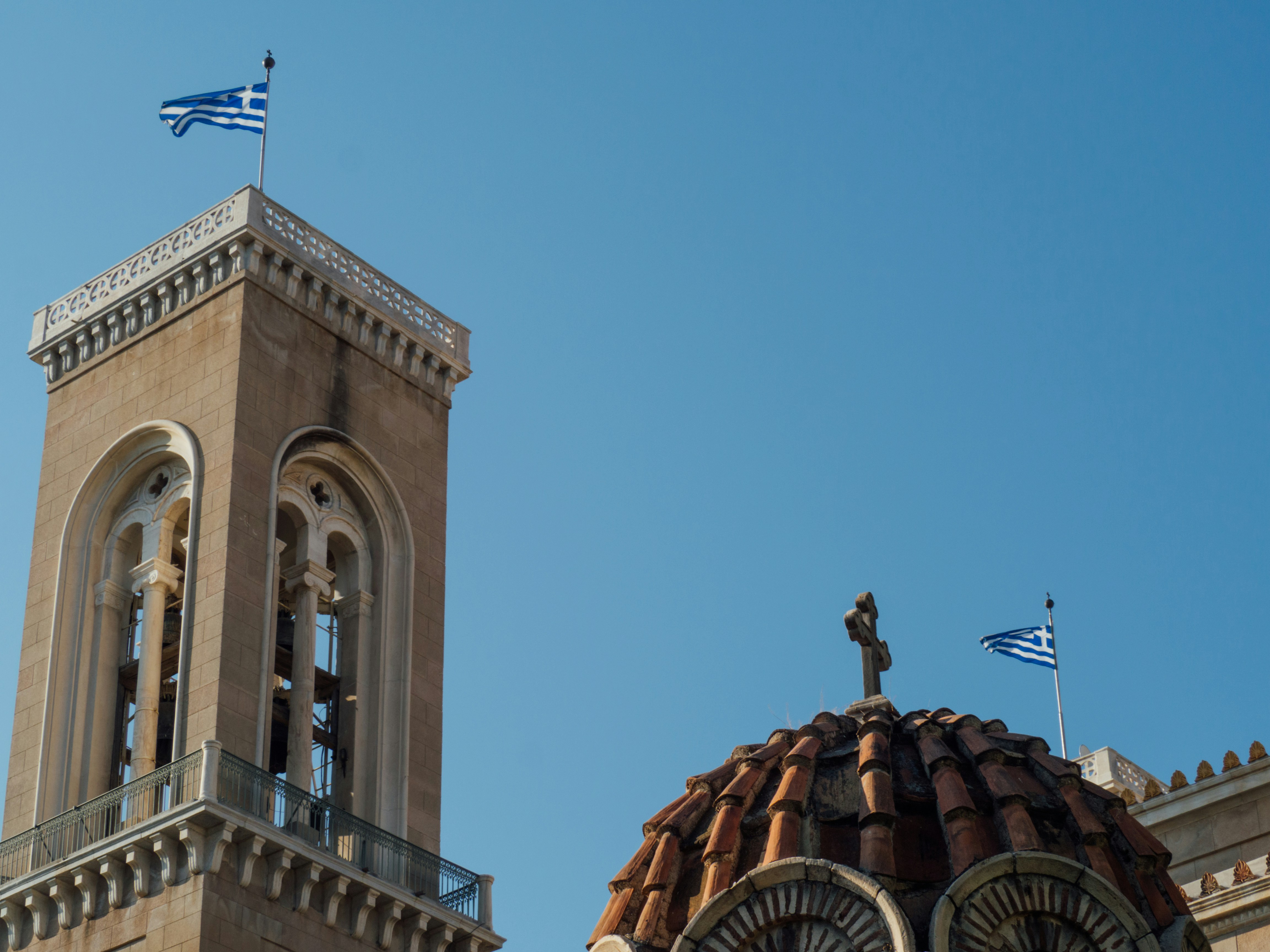 Flag atop a Byzantine-like tower under a clear blue sky