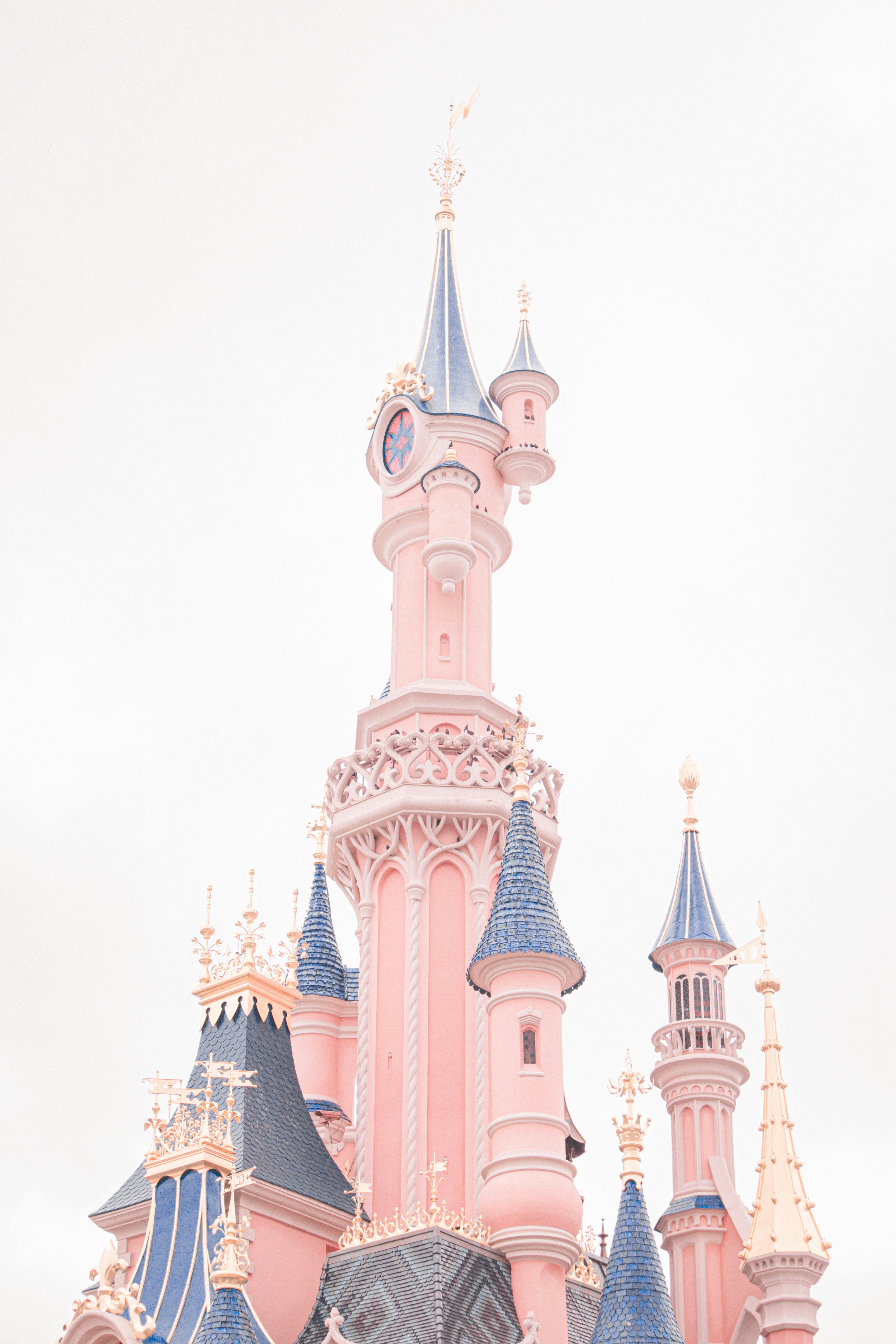 A pink and blue castle with a clock on it photo – Free France Image on ...
