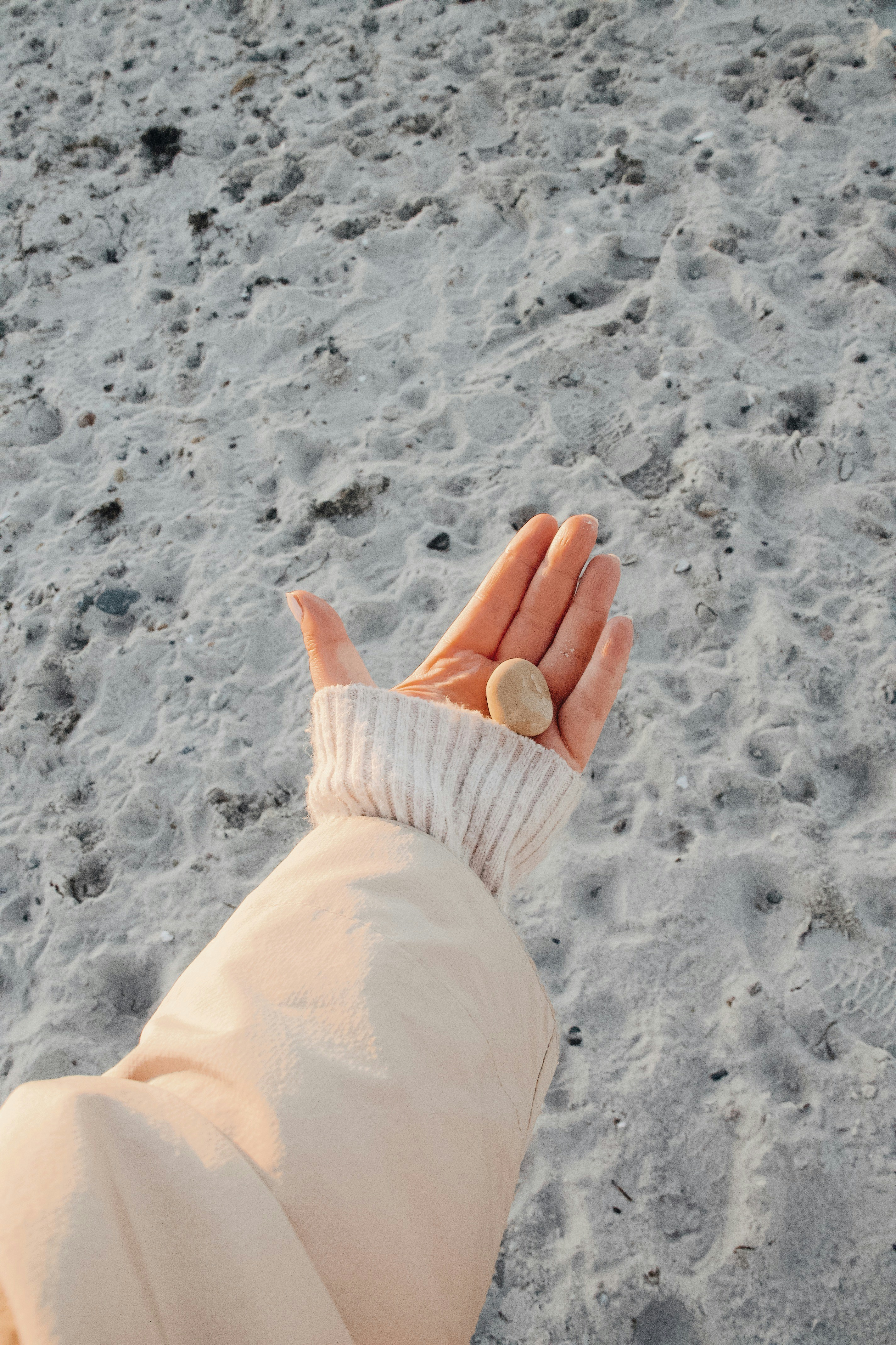 Pebble in Hand on Wind-Worn Sand