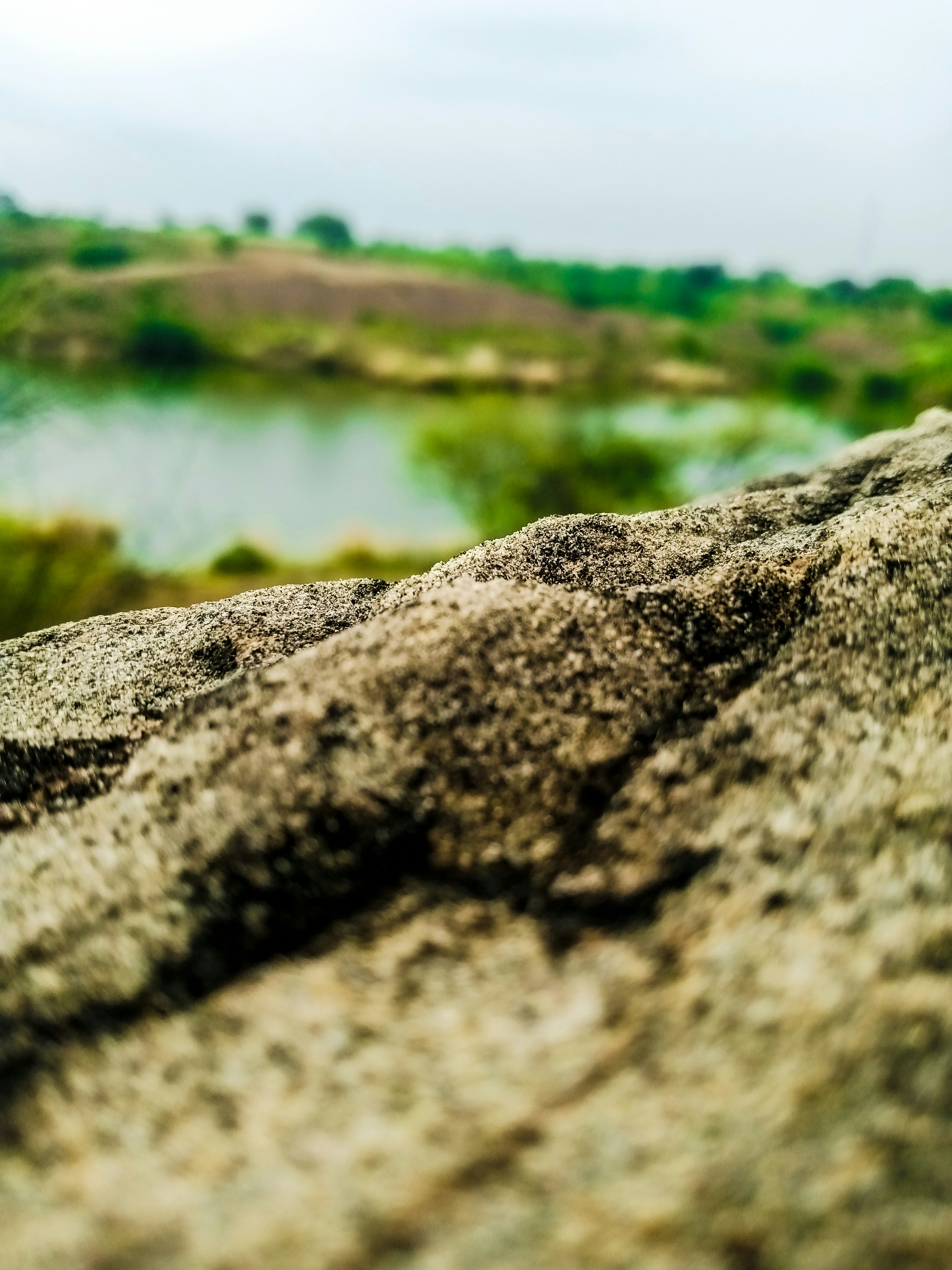Granite in Focus: Close-Up Texture with a Dimensional Lake Backdrop