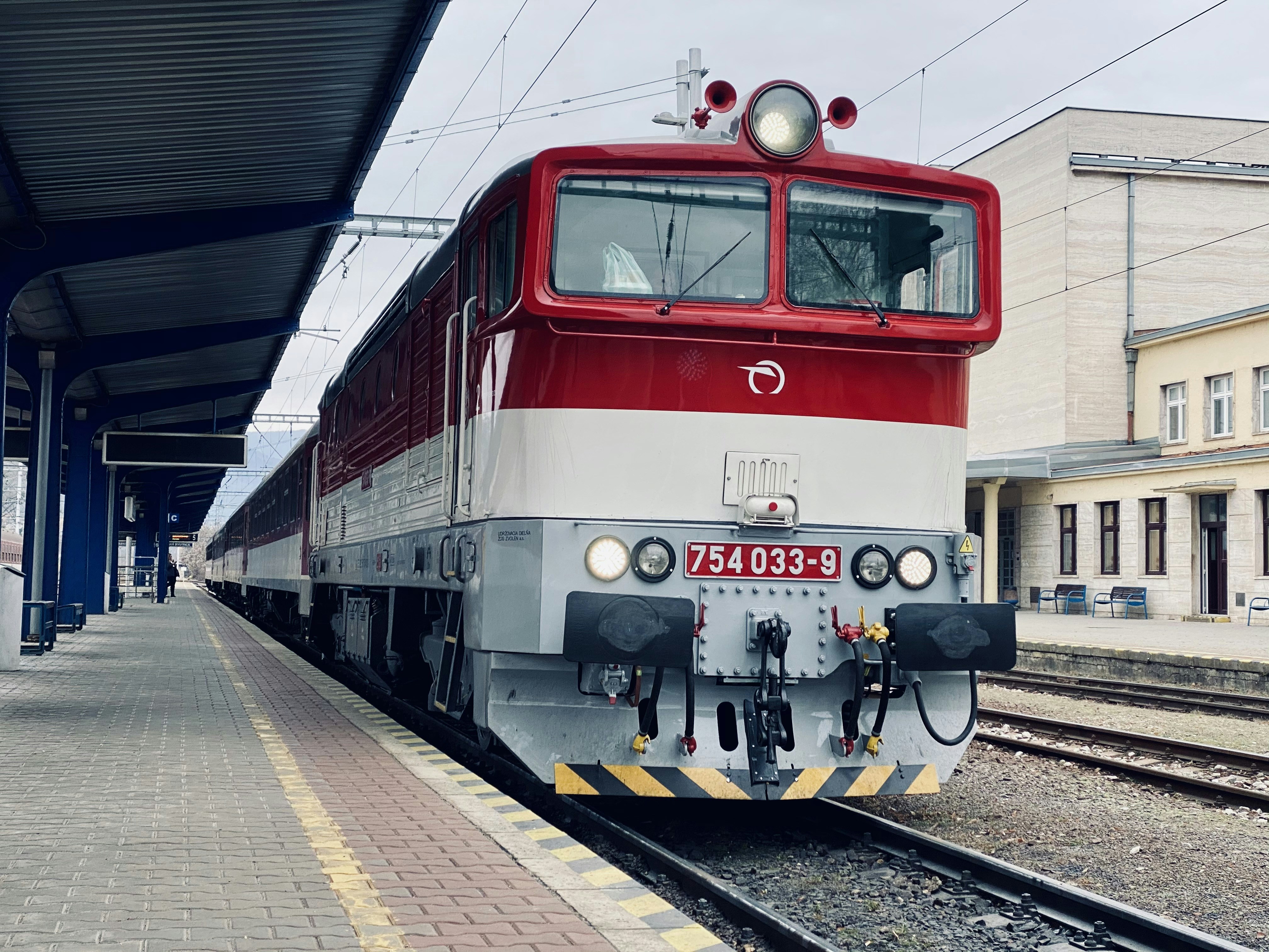 Foto zum Thema Ein rot-weißer Zug fährt in einen Bahnhof ein ...