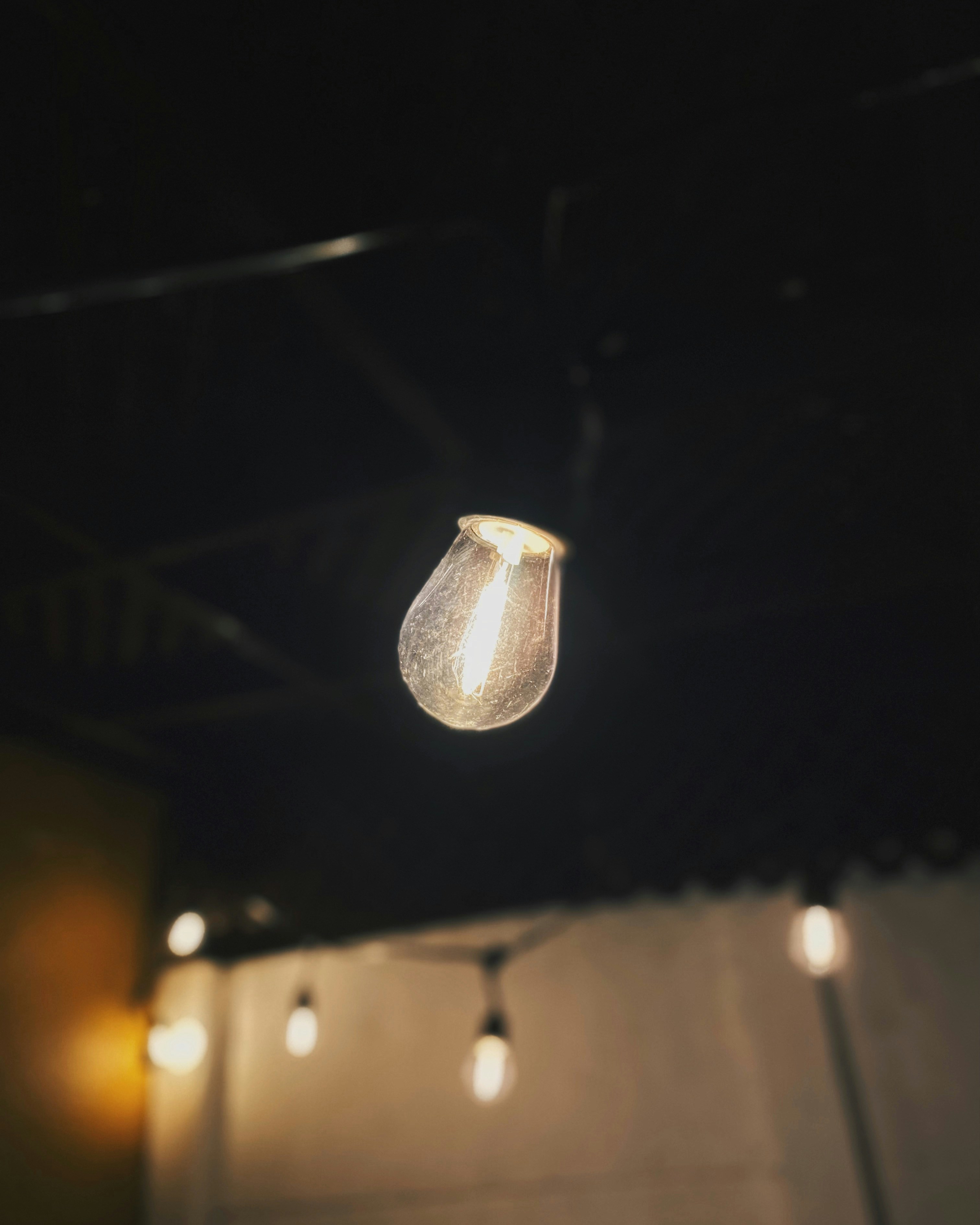 a light bulb hanging from a ceiling in a dark room