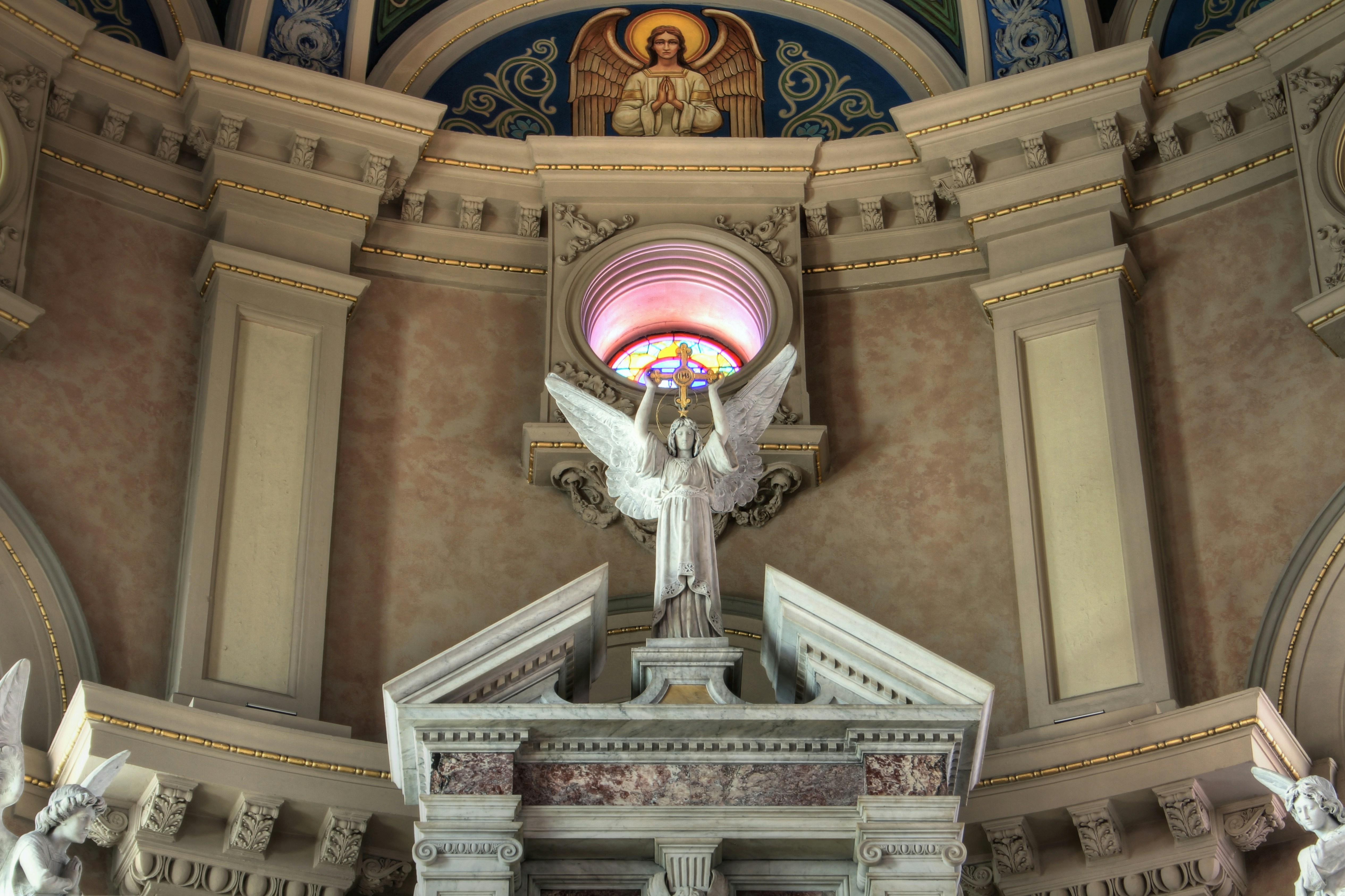 Catholic church interior | a statue of an angel on top of a building