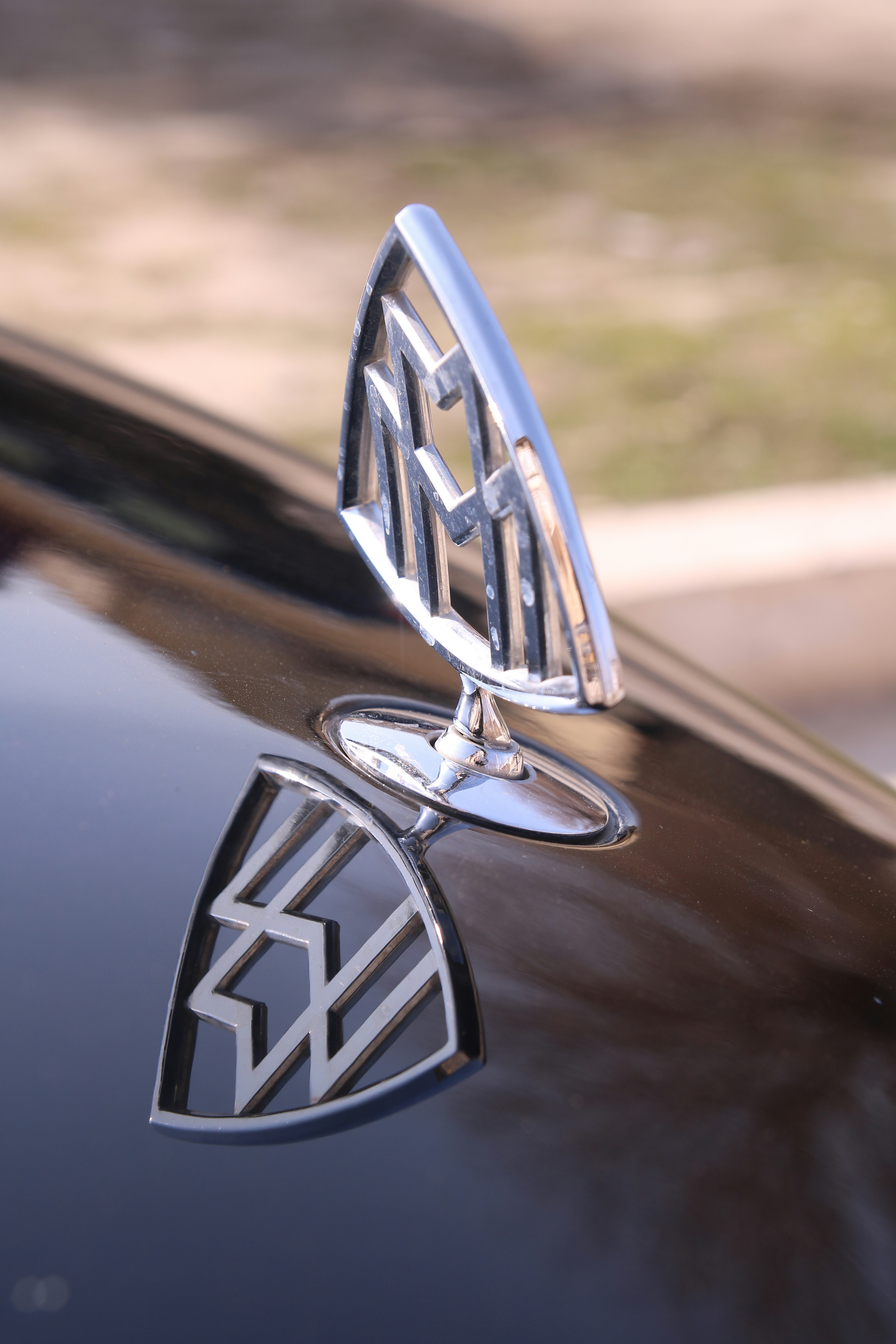 Maybach emblem, mirror | a close up of the hood ornament on a car