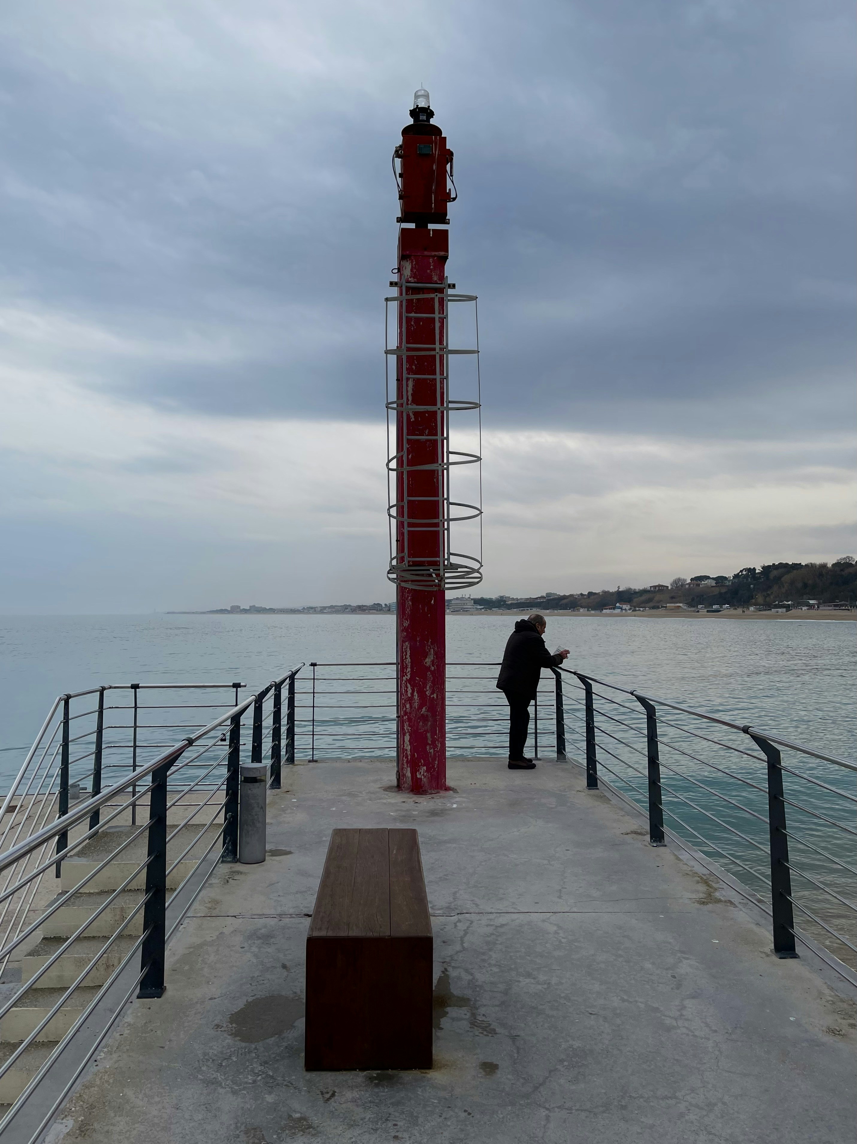 a person standing on a pier next to the ocean