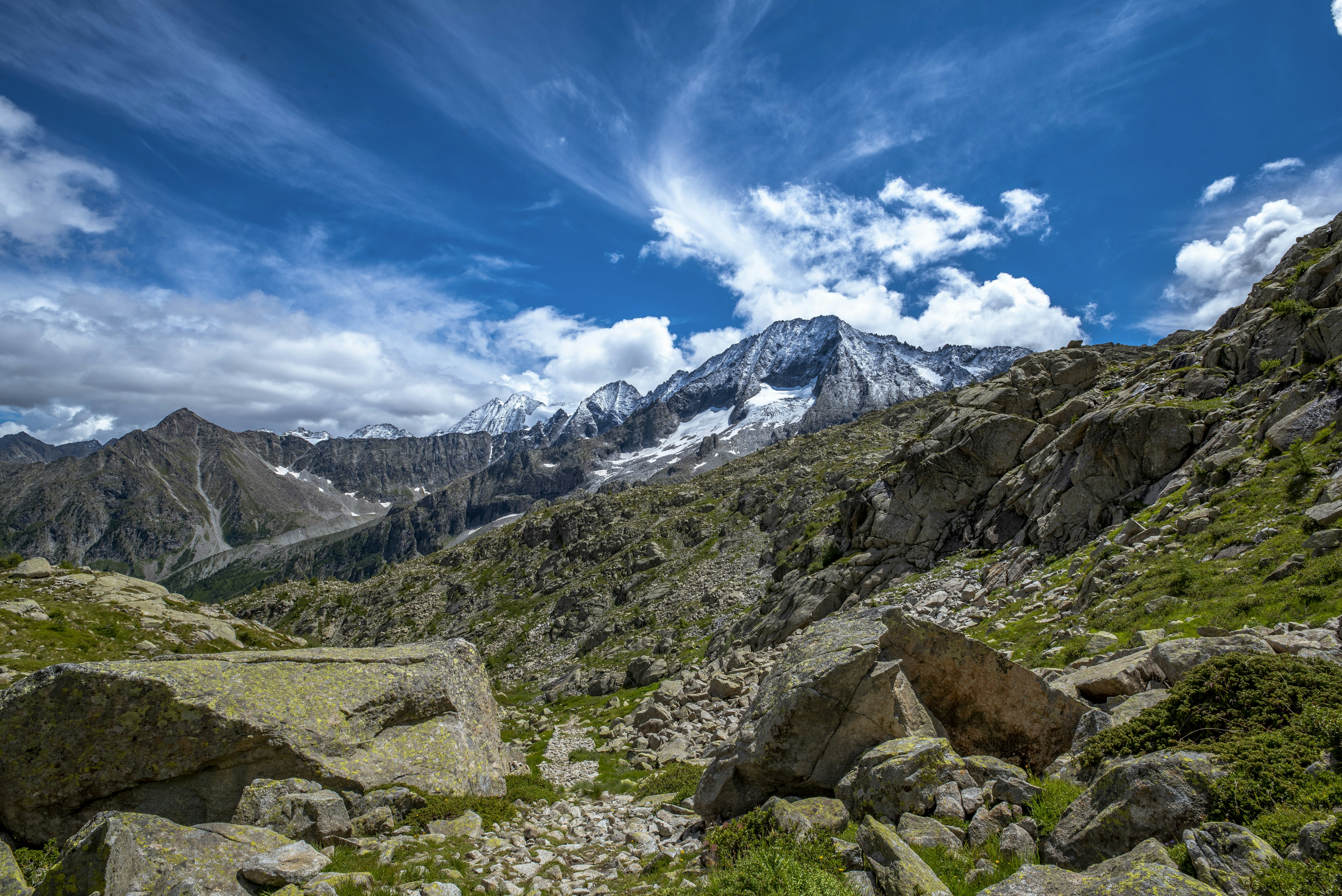 A view of a mountain range with rocks and grass photo – Free Tonale ...