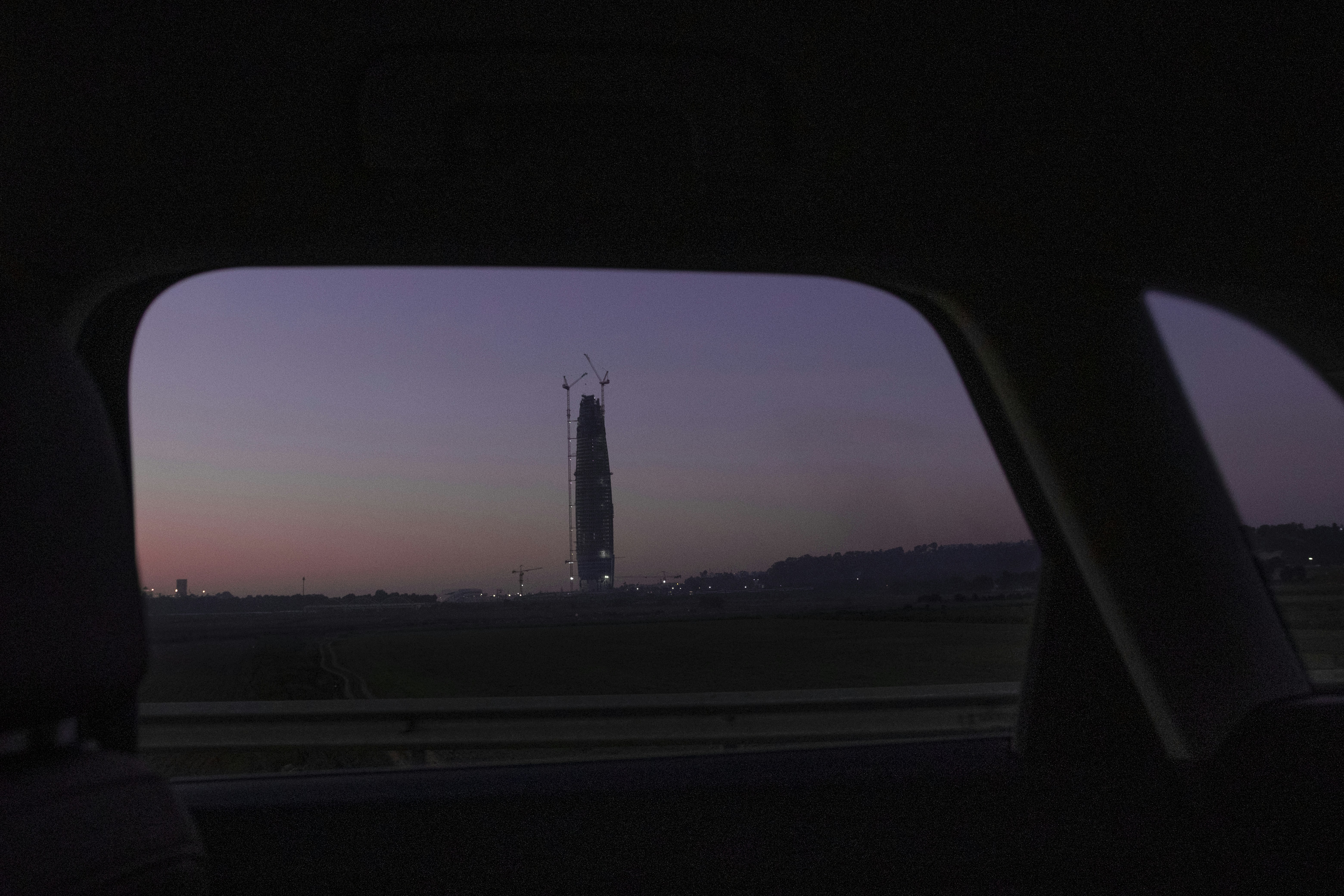 a view of a tall building from inside a car