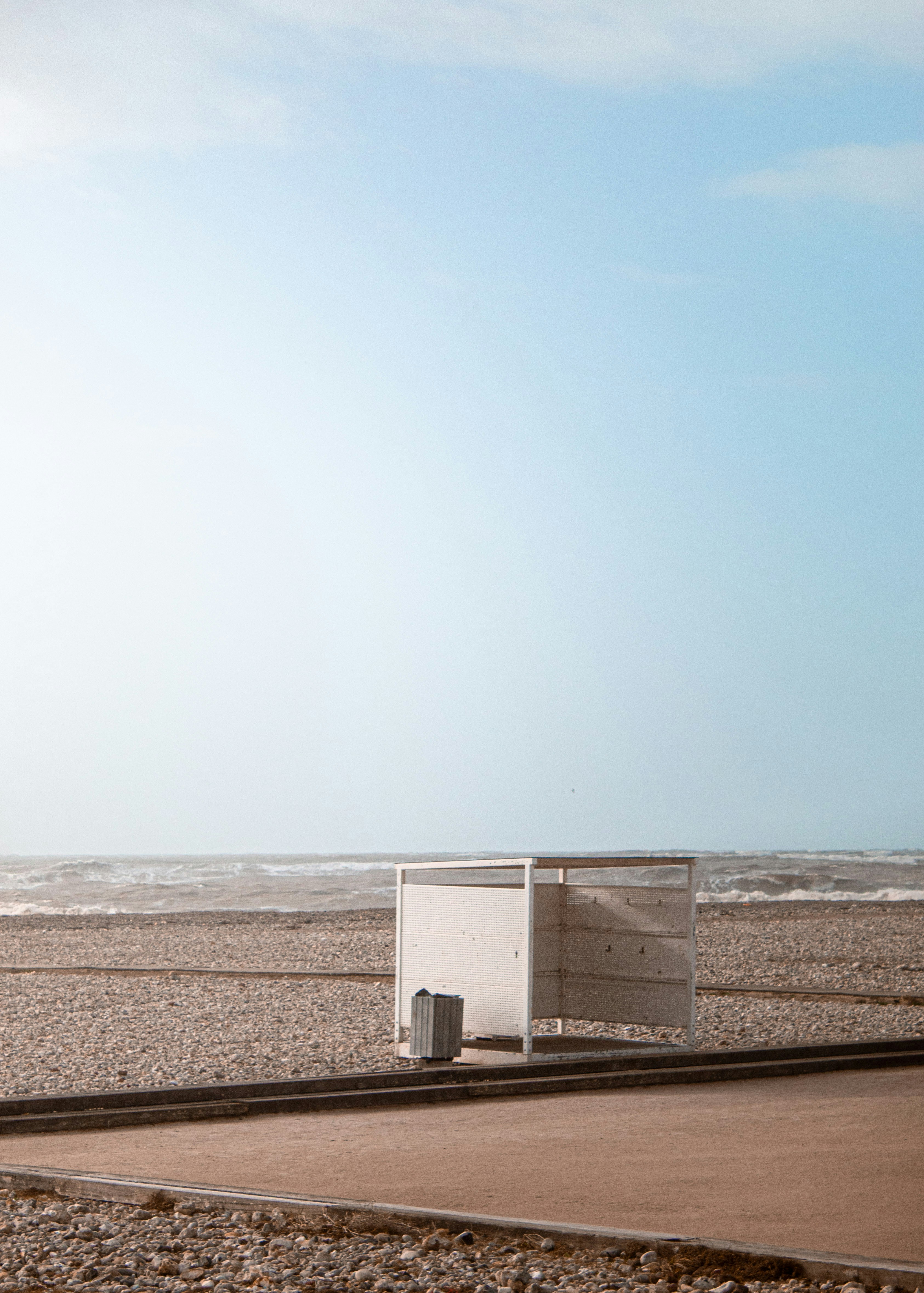 The Quiet Sentinel: A White Shelter Framed by Sea and Sky