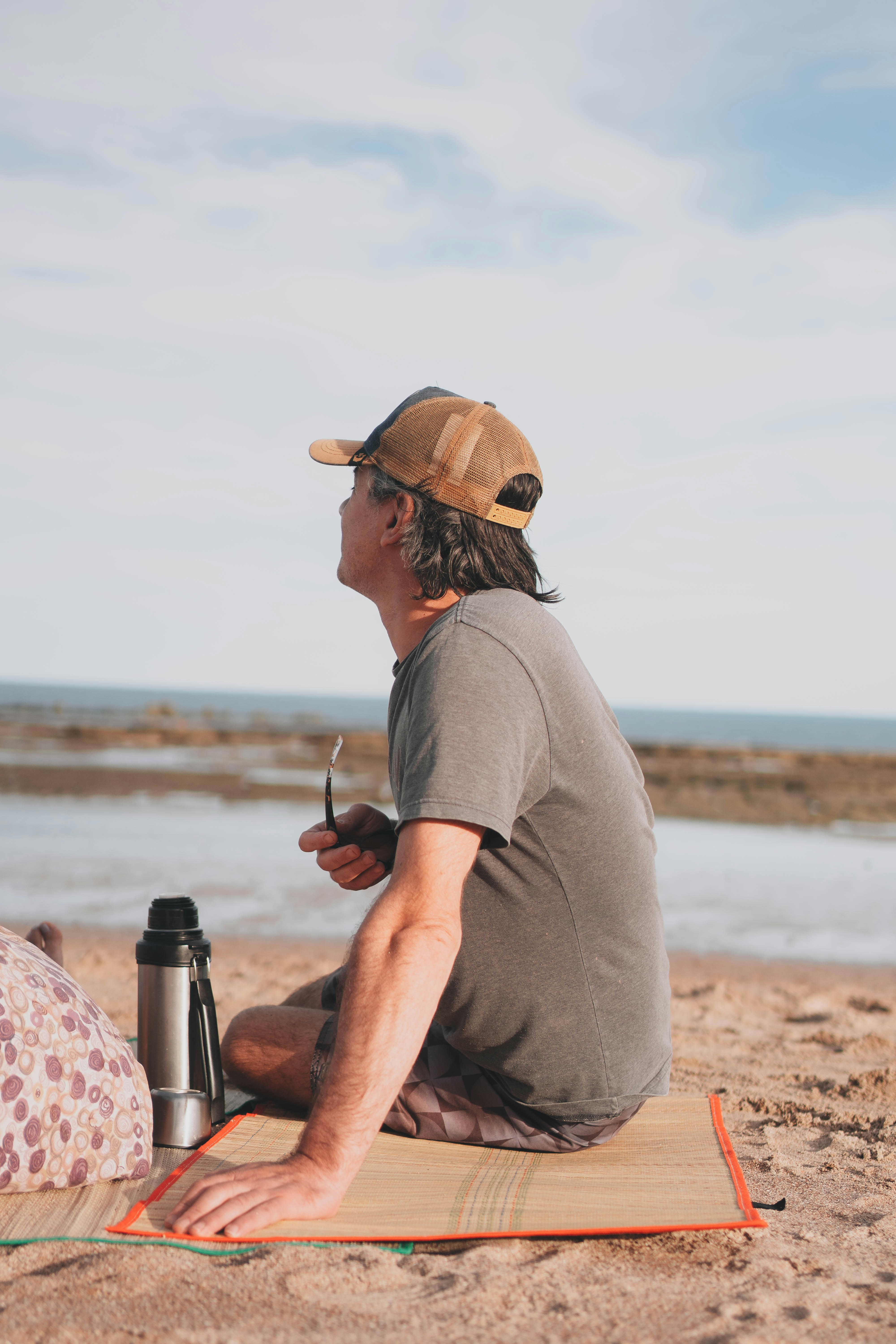 a man sitting on a towel on the beach