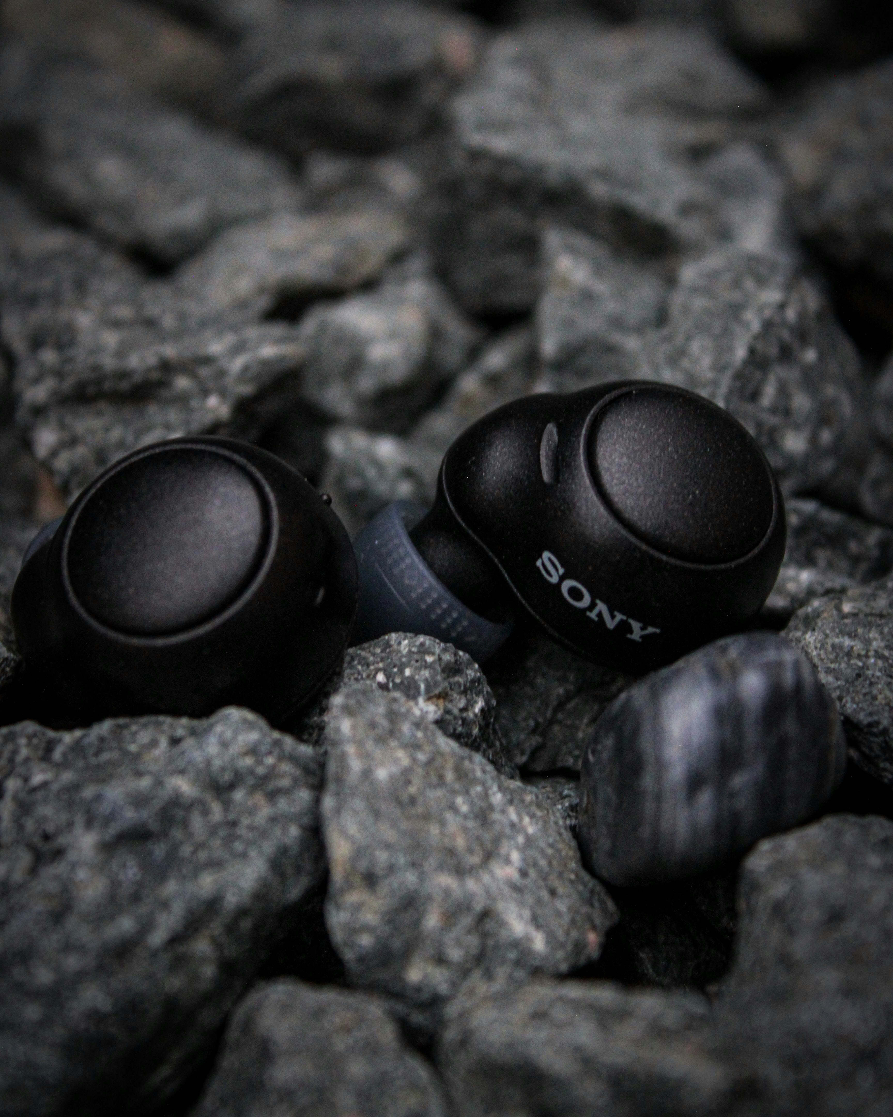 A pair of sony headphones laying on a pile of rocks photo – Free Rock ...