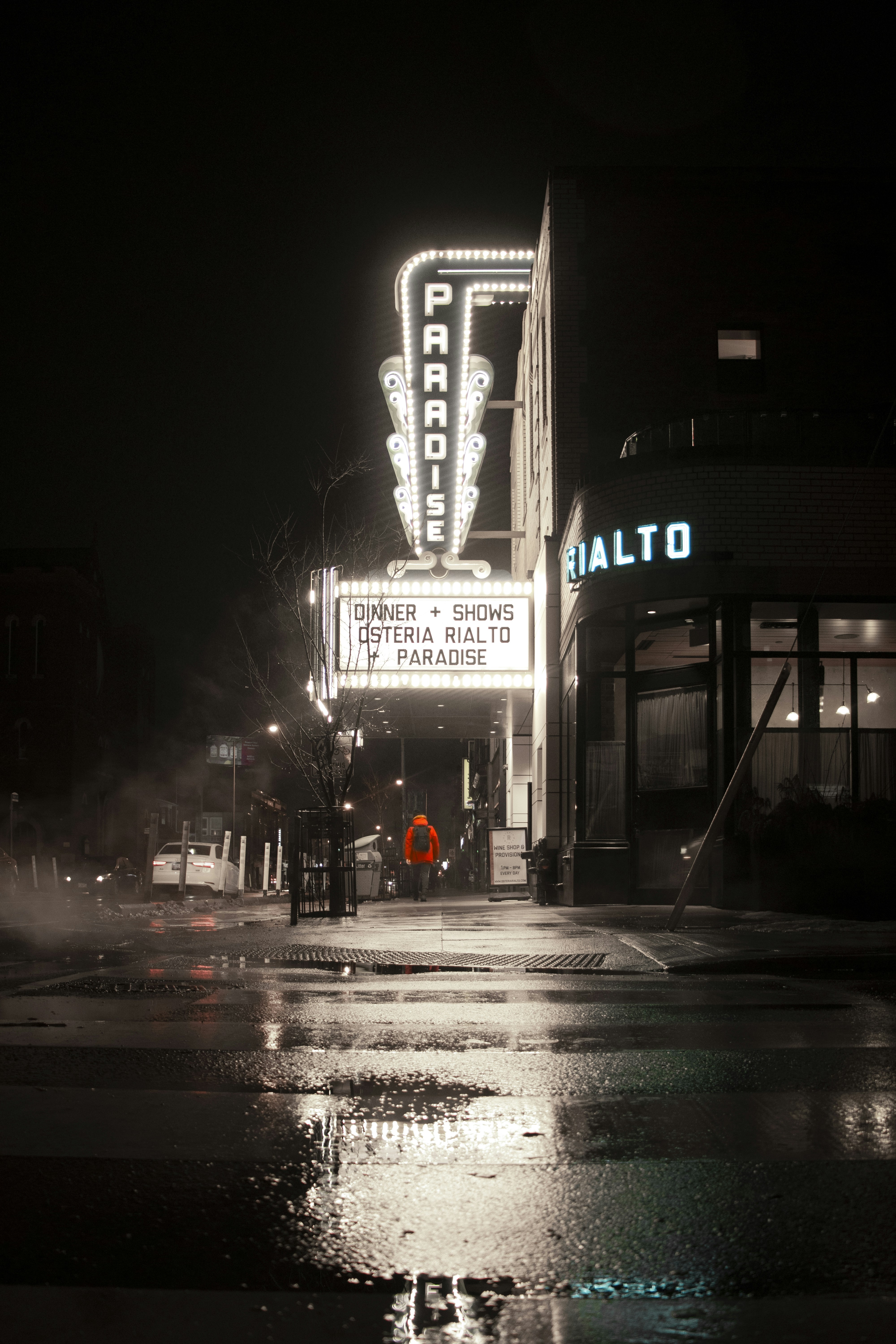 Neon Paradise at Midnight: A Lone Figure in an Orange Coat