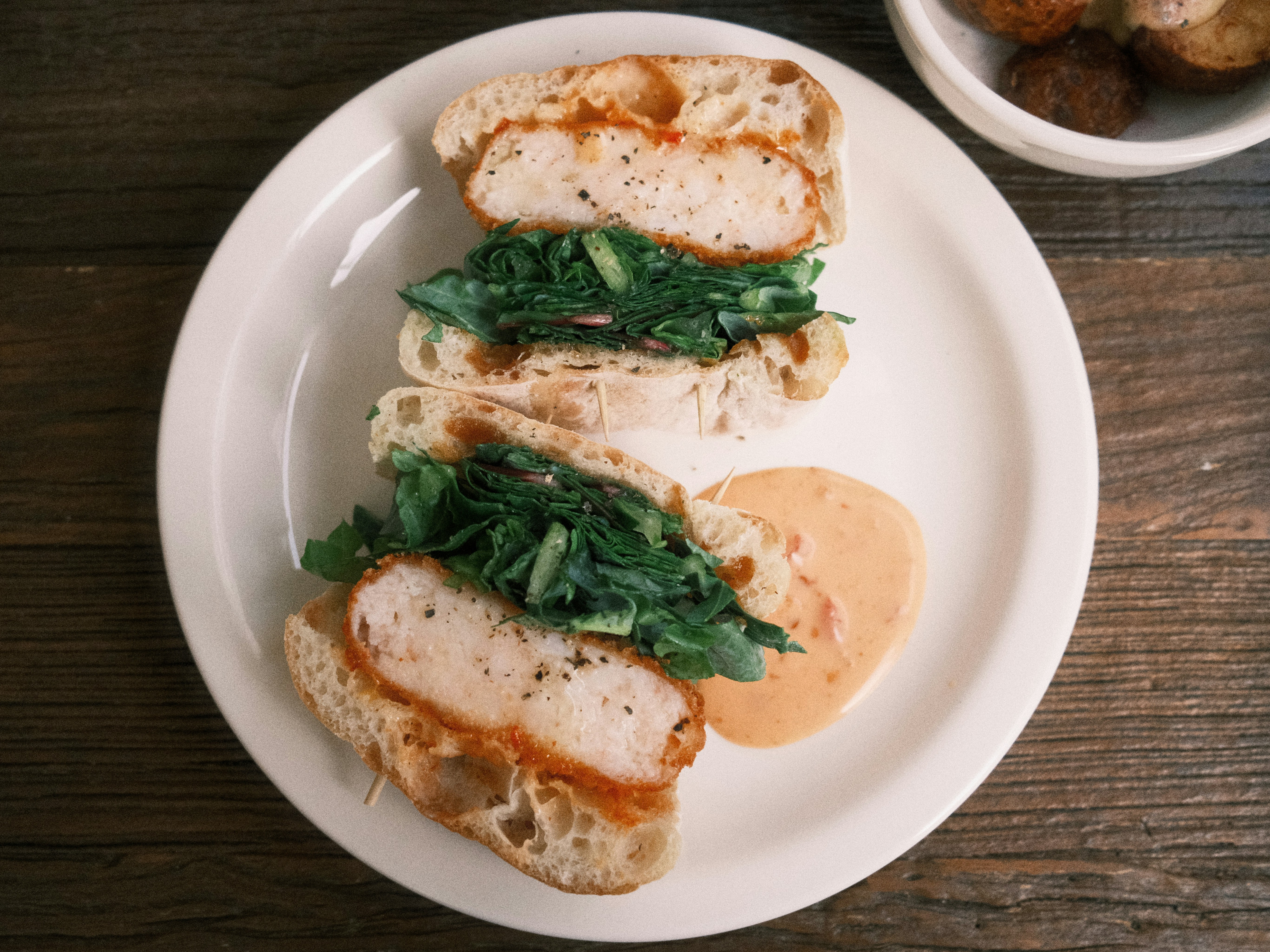 Spinach-packed panini halves on a rustic wooden table