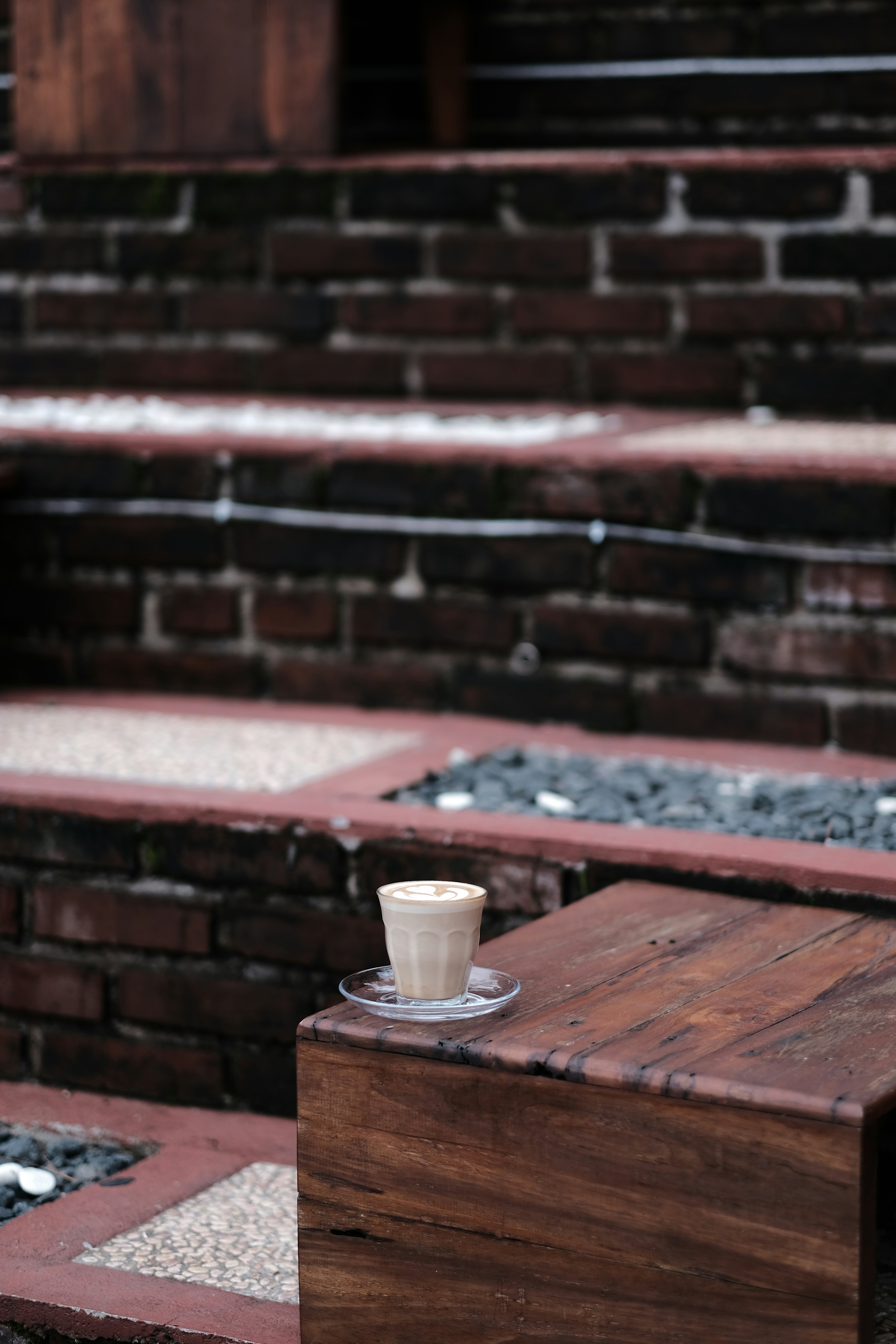 Latte on Timber: a solitary cup framed by brick stairs