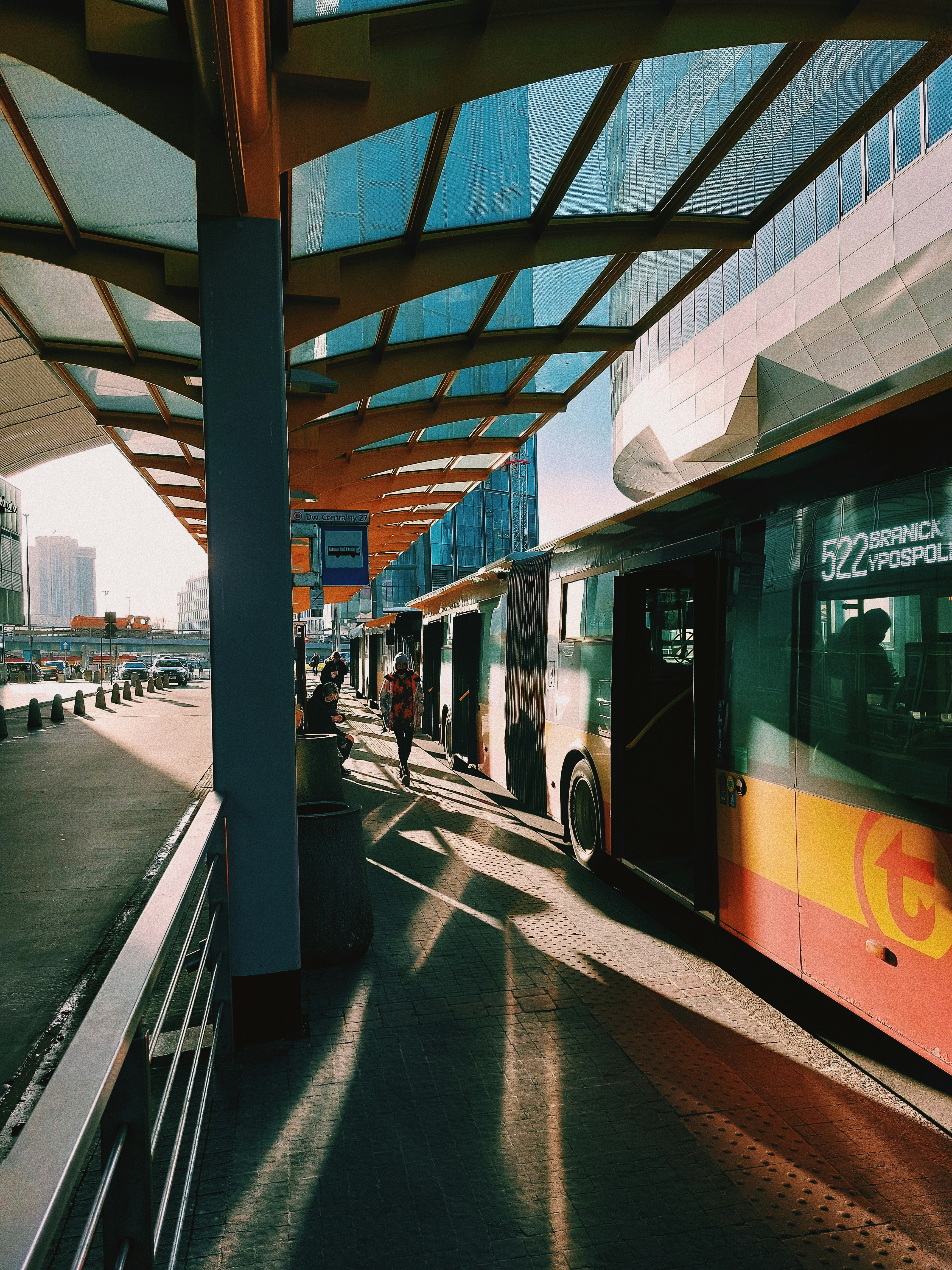 A bus parked in a bus station next to a building photo – Free Human ...