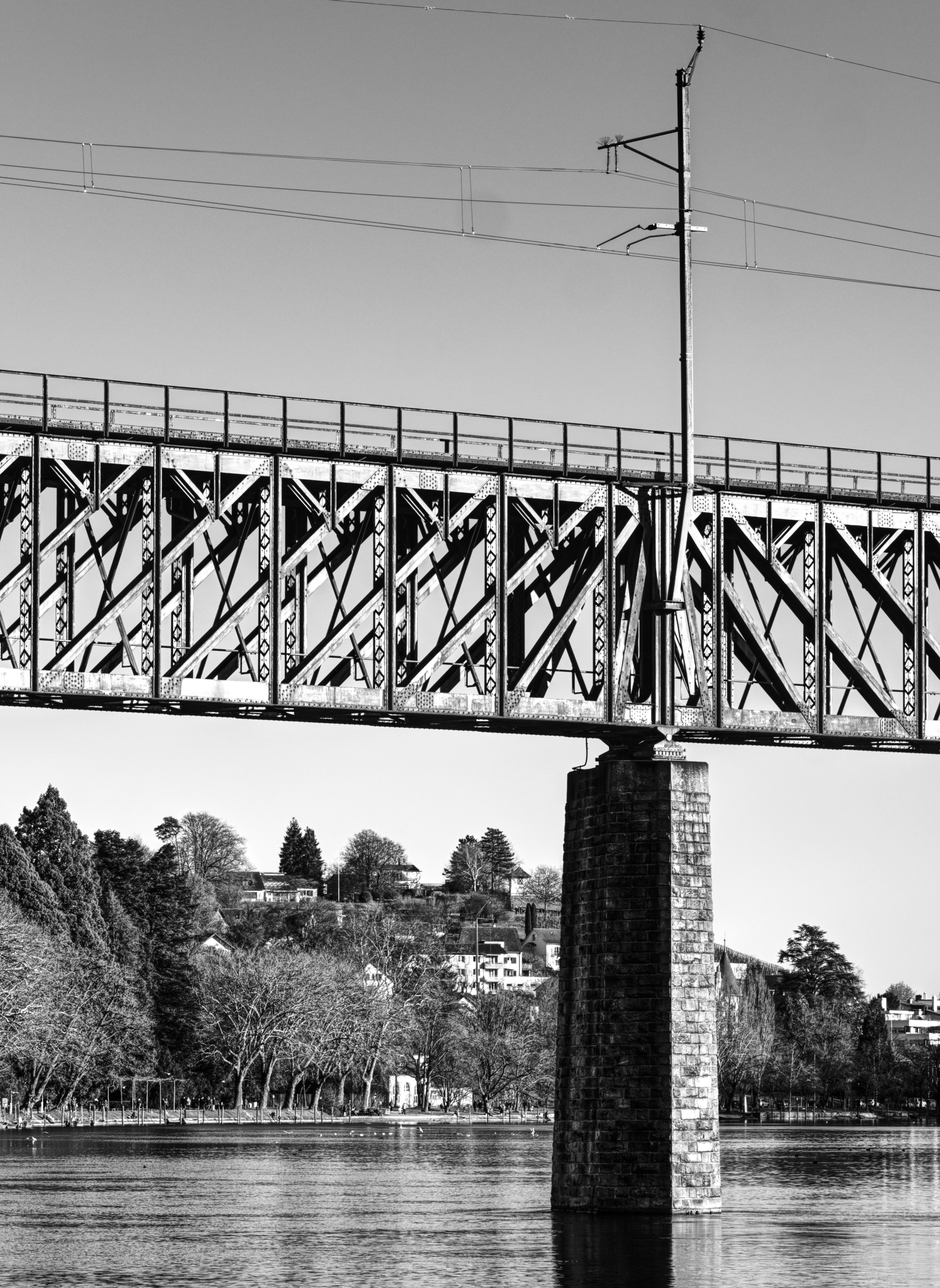 Iron Lattice Over the Quiet River: A Black-and-White Bridge Study