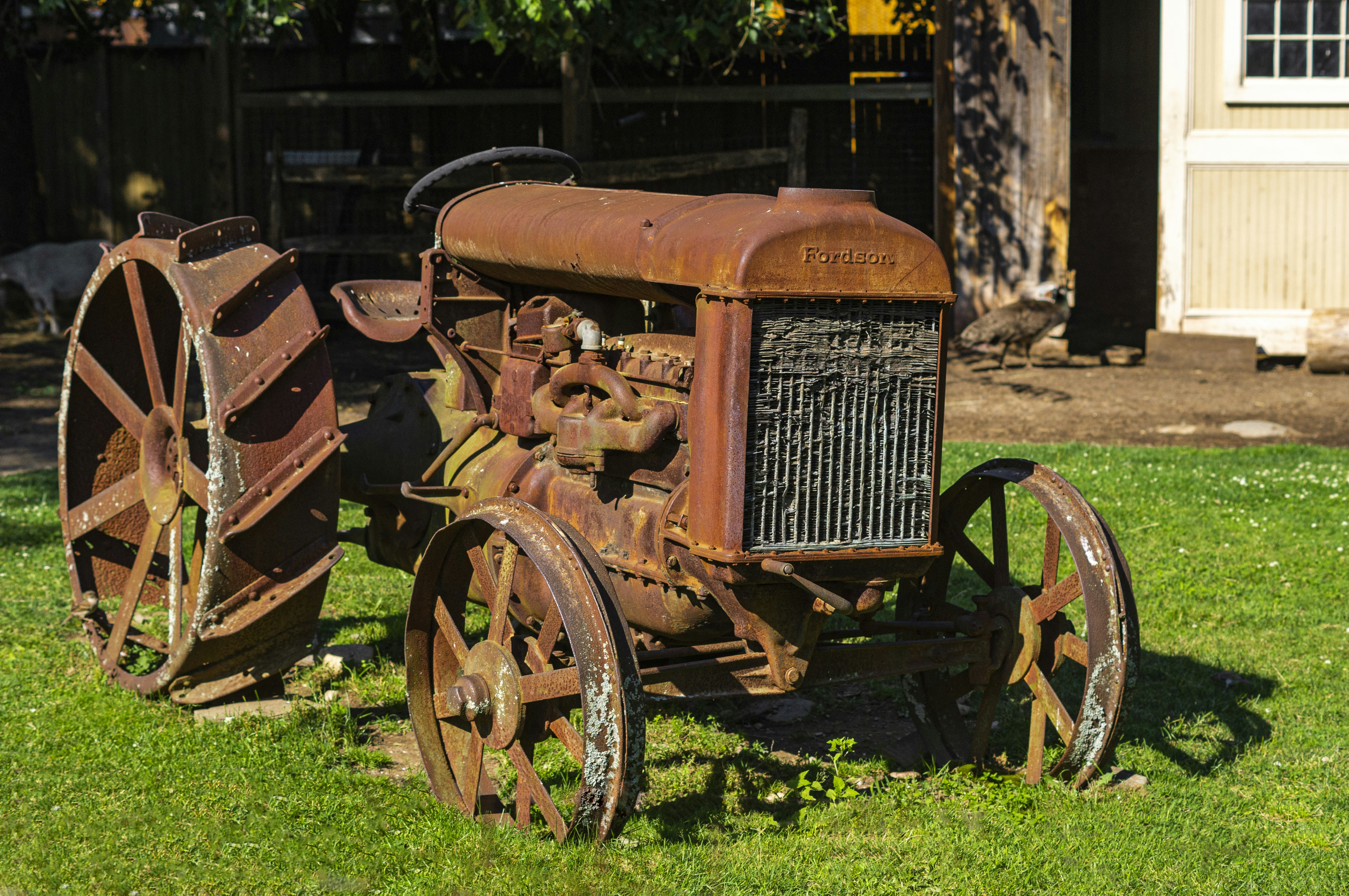 An old rusty tractor sitting in the grass photo – Free Rust Image on ...