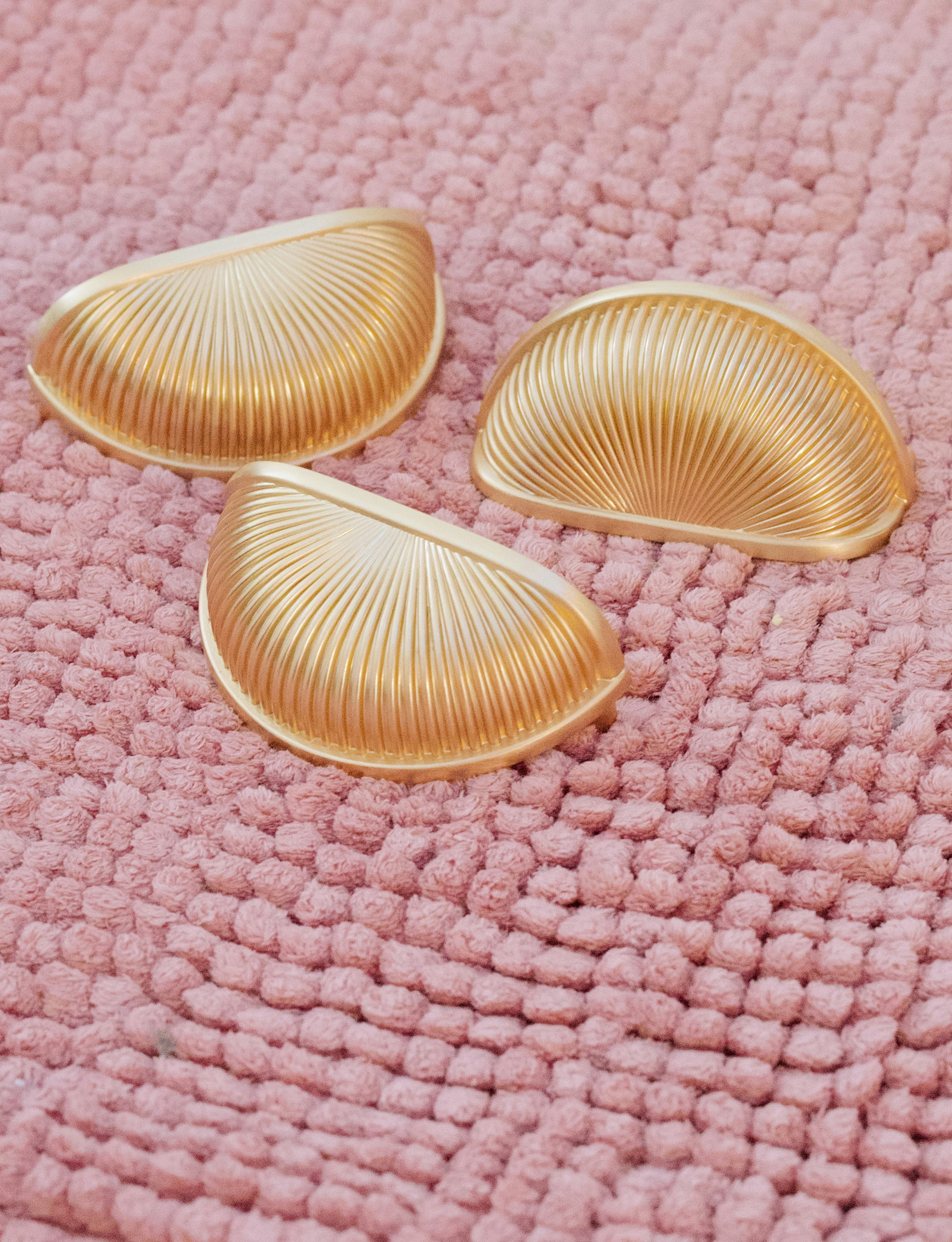 Gilded Seashell Trio on a Plush Pink Carpet