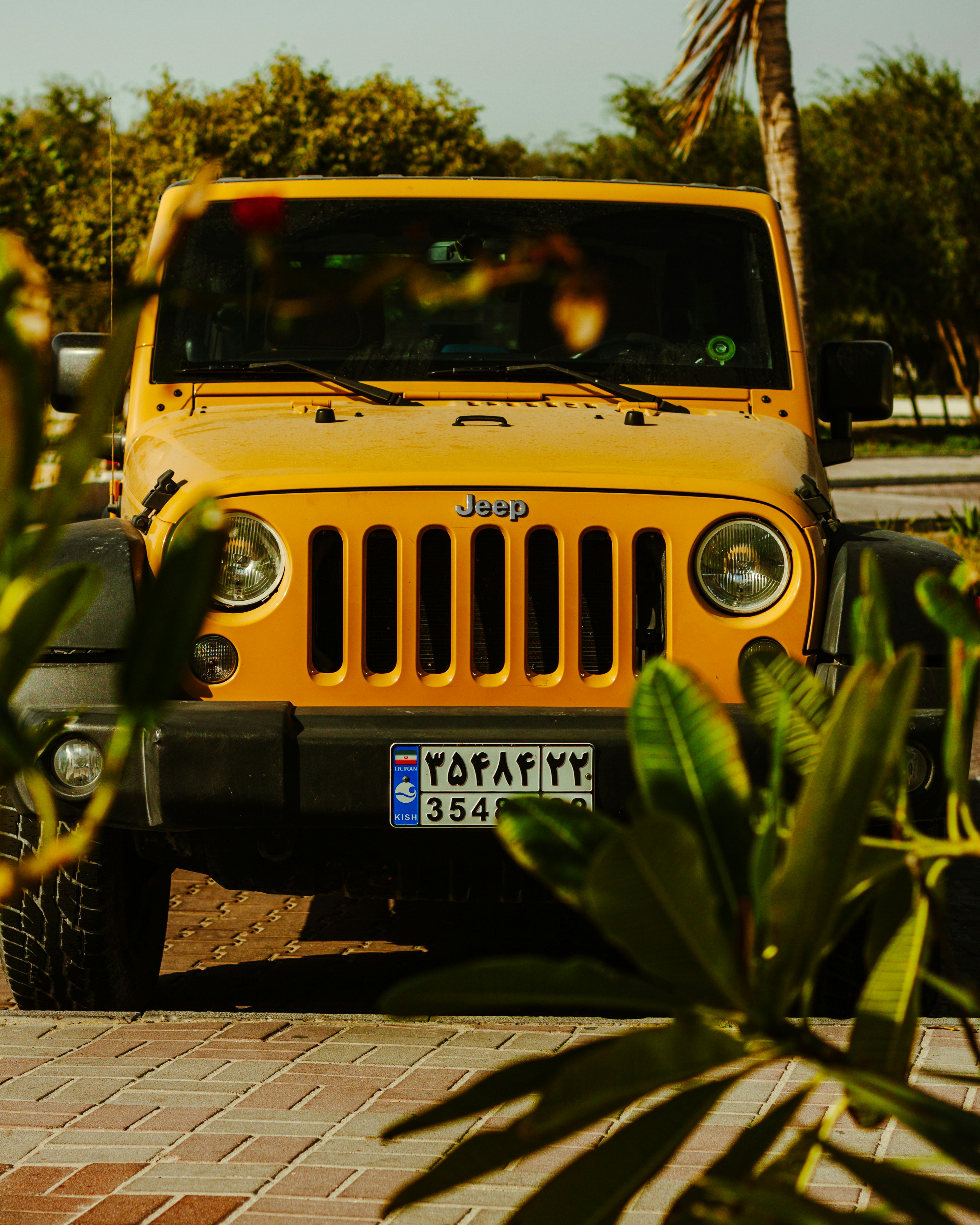 A yellow jeep parked on the side of the road photo – Free Kish Image on ...