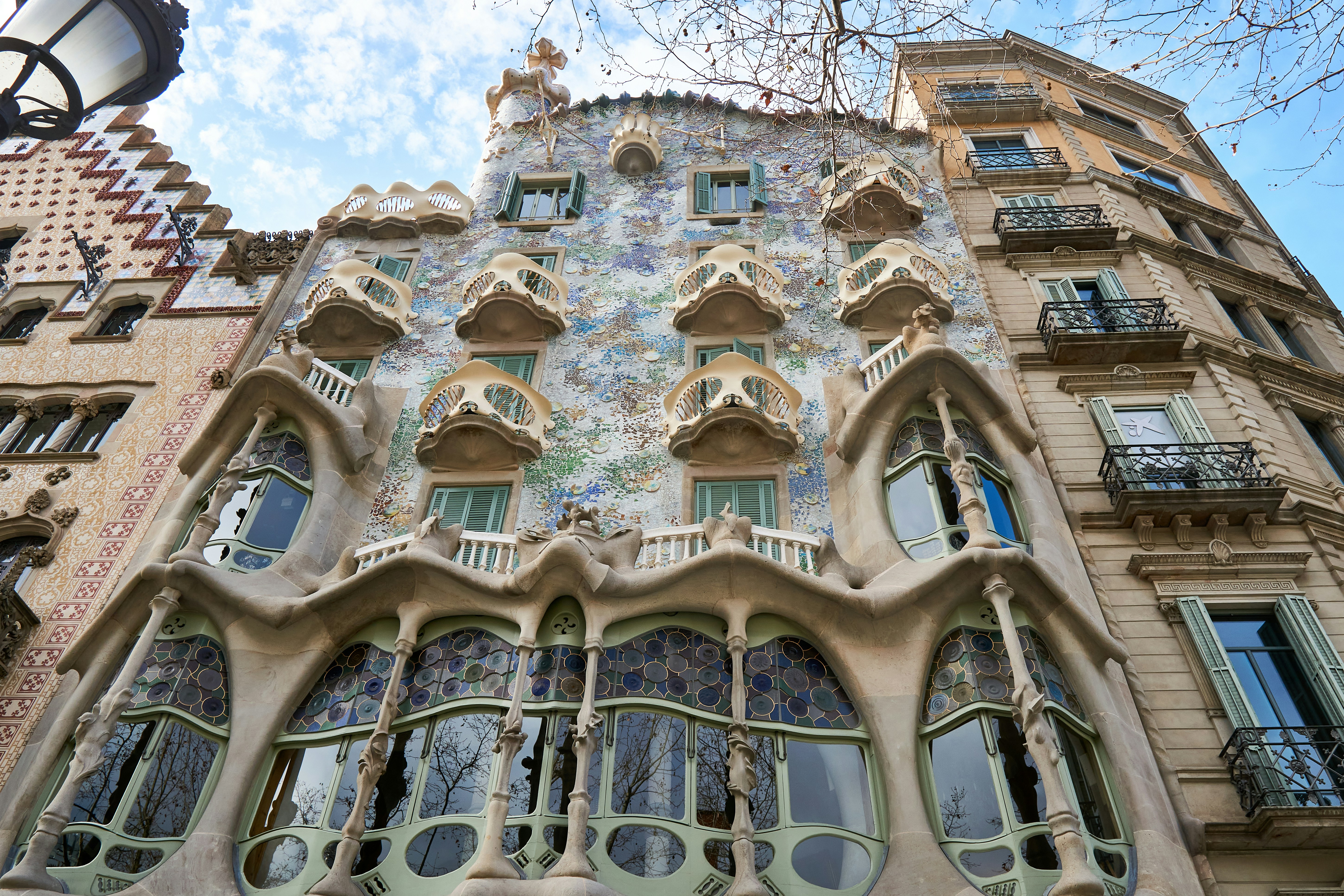 Intricate facade of Casa Batlló showcasing colorful mosaics and organic shapes, highlighting Gaudí's unique architectural style.
