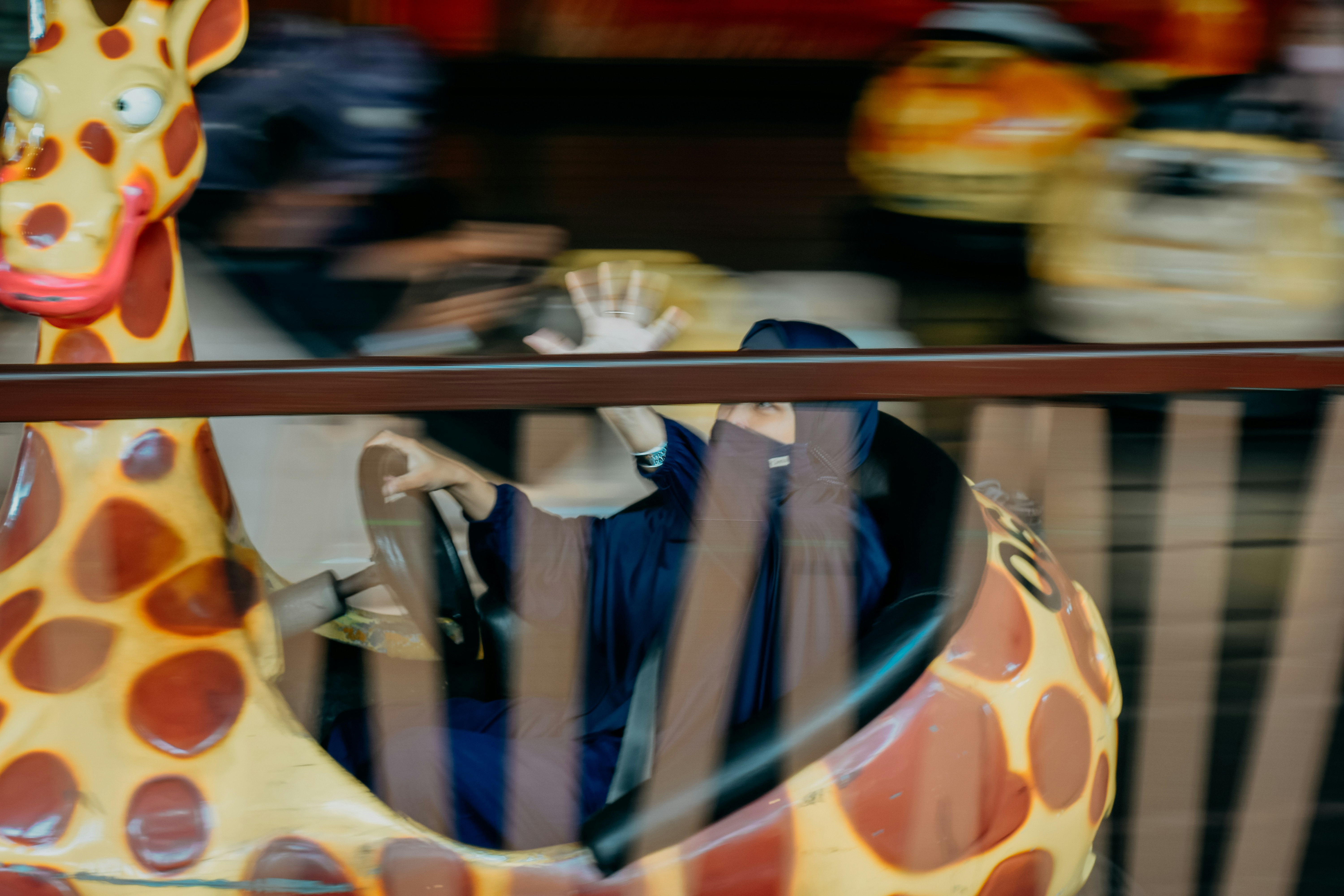 A giraffe riding on top of a ride at a carnival photo – Free Amusement ...