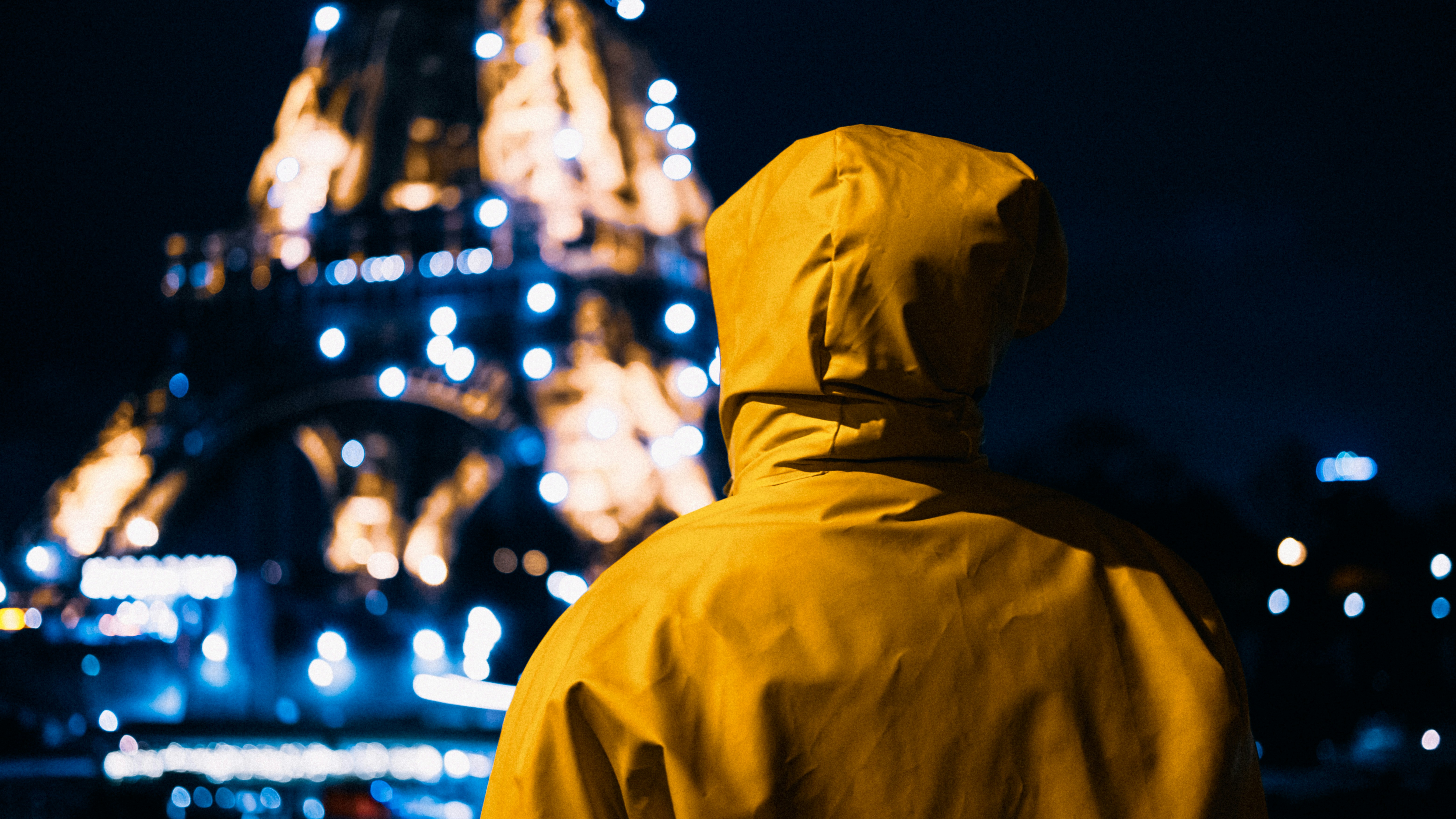 Foto Una persona con un impermeable amarillo de pie frente a la Torre ...