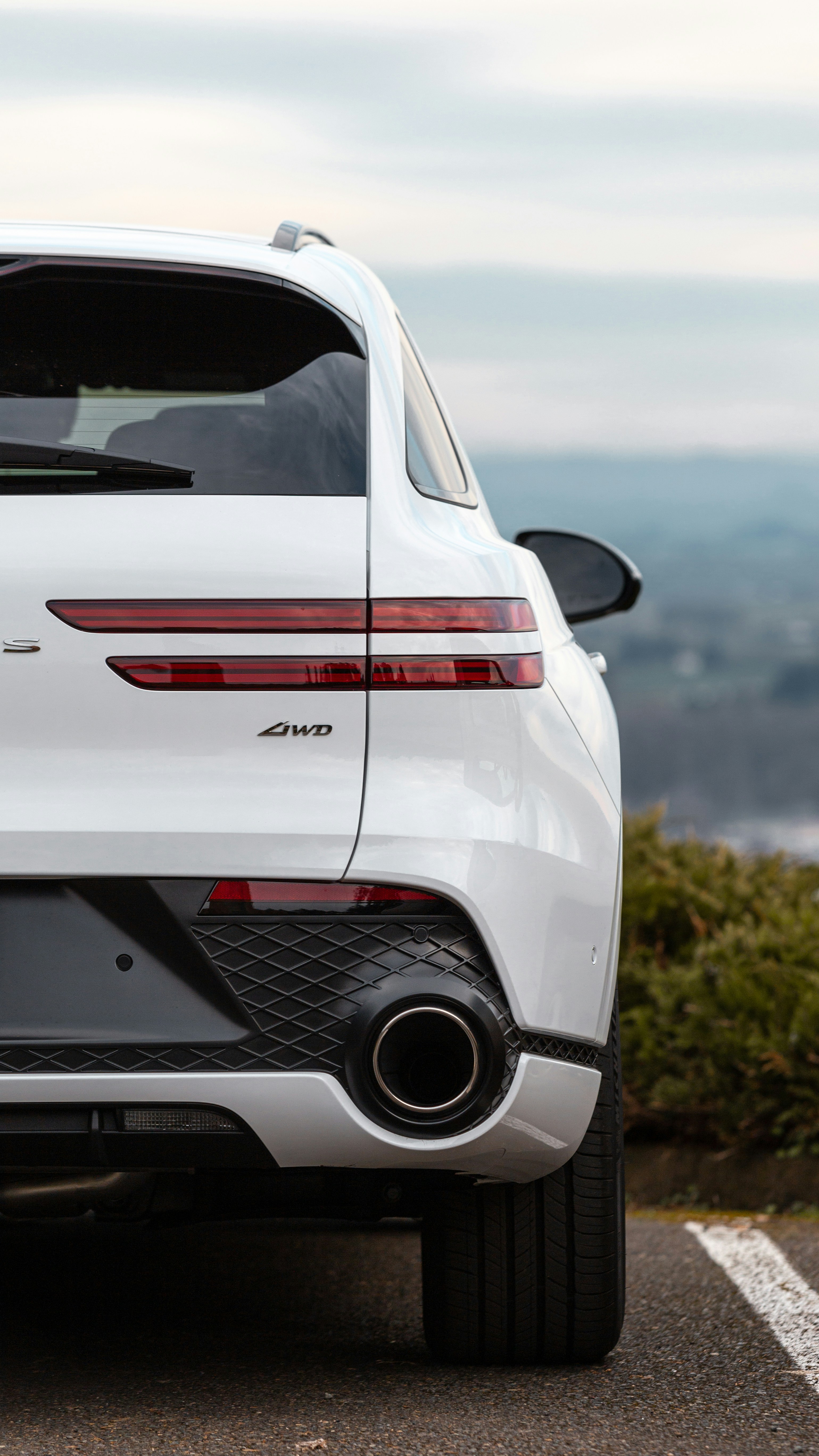 Rear View Reverie: A White SUV with Bold Tail Lights and Exposed Exhaust