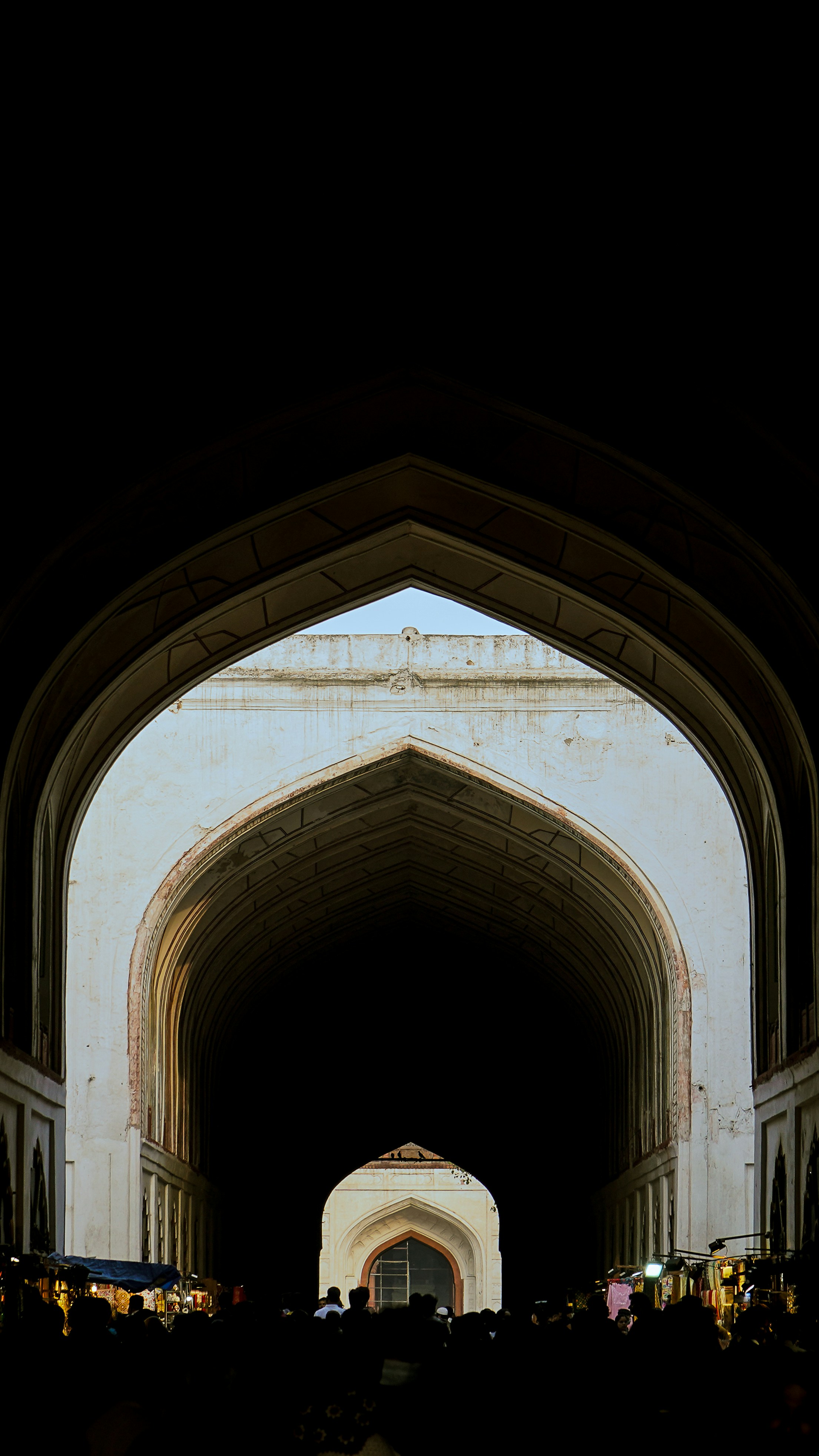 Foto zum Thema Ein großer Torbogen mit einer Uhr an der Seite ...