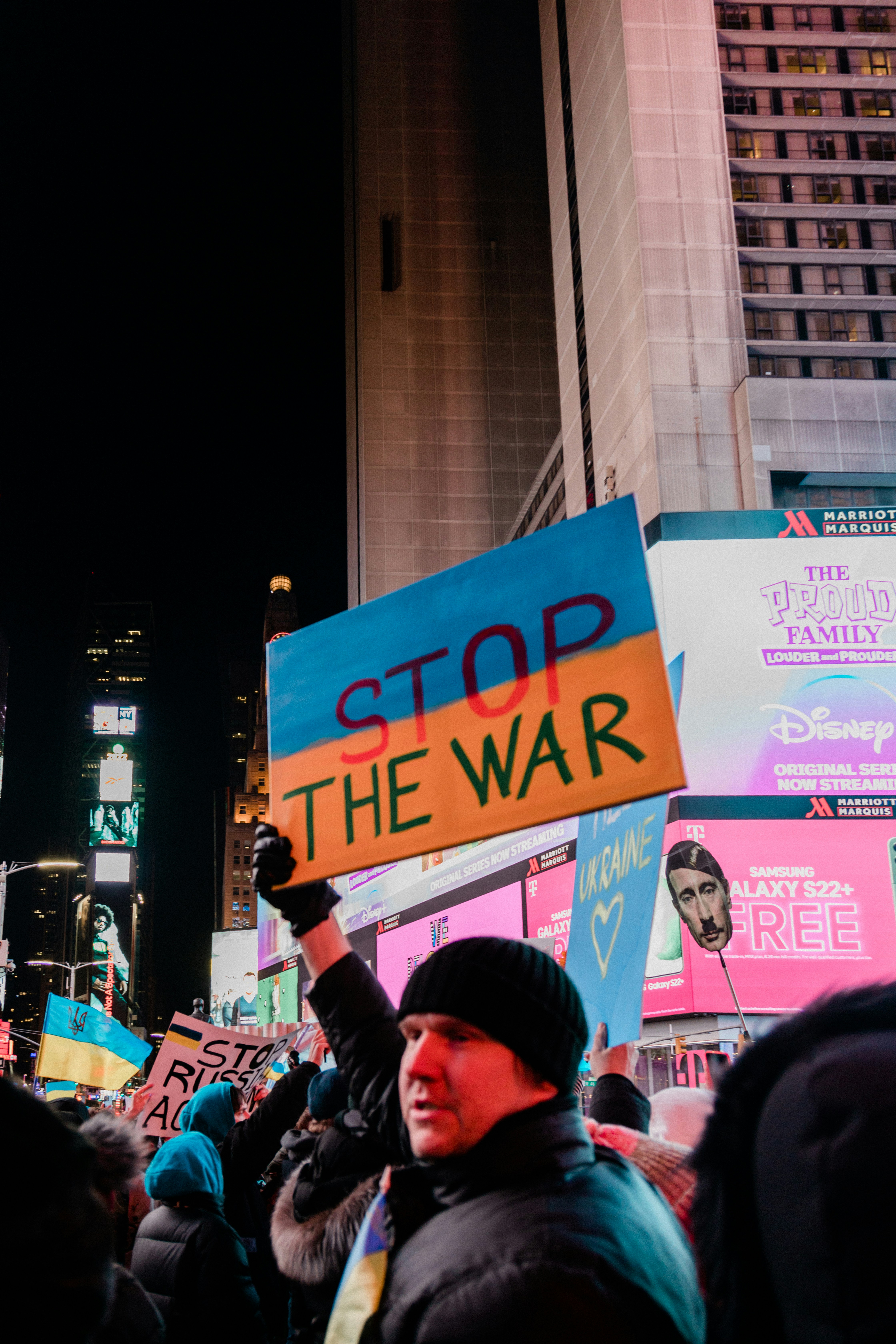 A crowd of people holding up signs in the street photo – Free New york ...