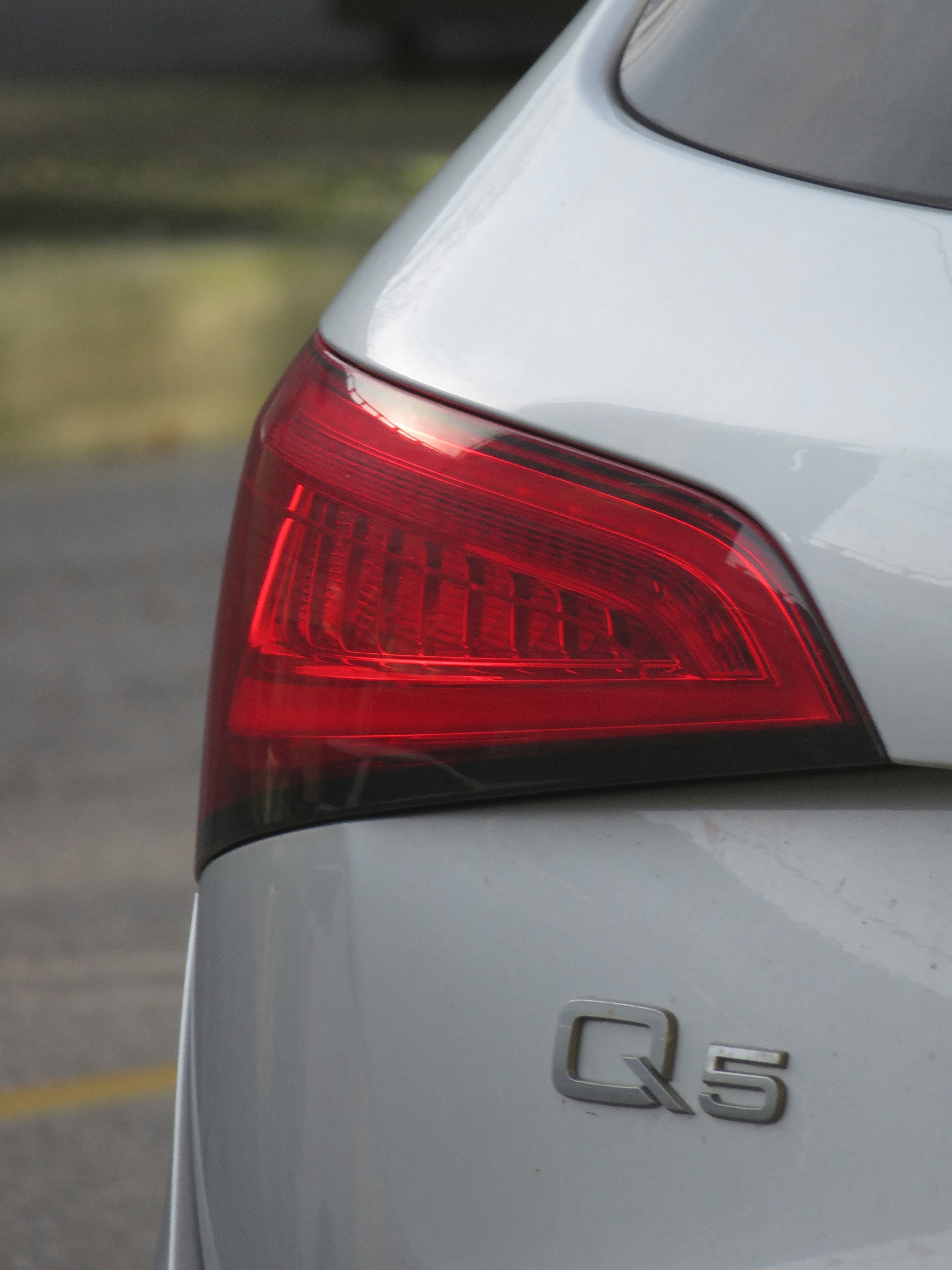 Rear Quarter Panel of Audi Q5: Red Tail Light & Badge in Focus