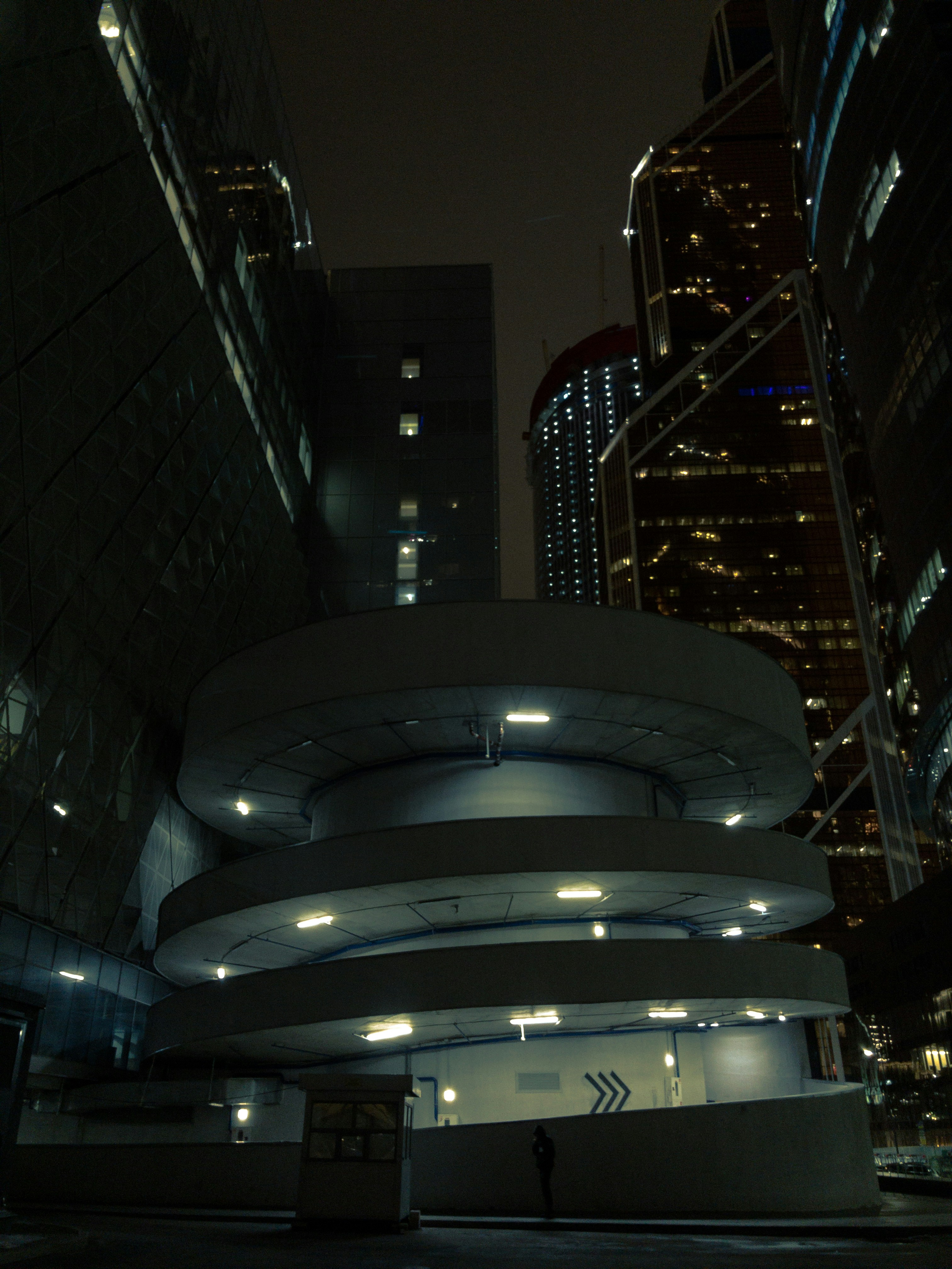 Un edificio con una entrada circular en medio de una ciudad por la ...